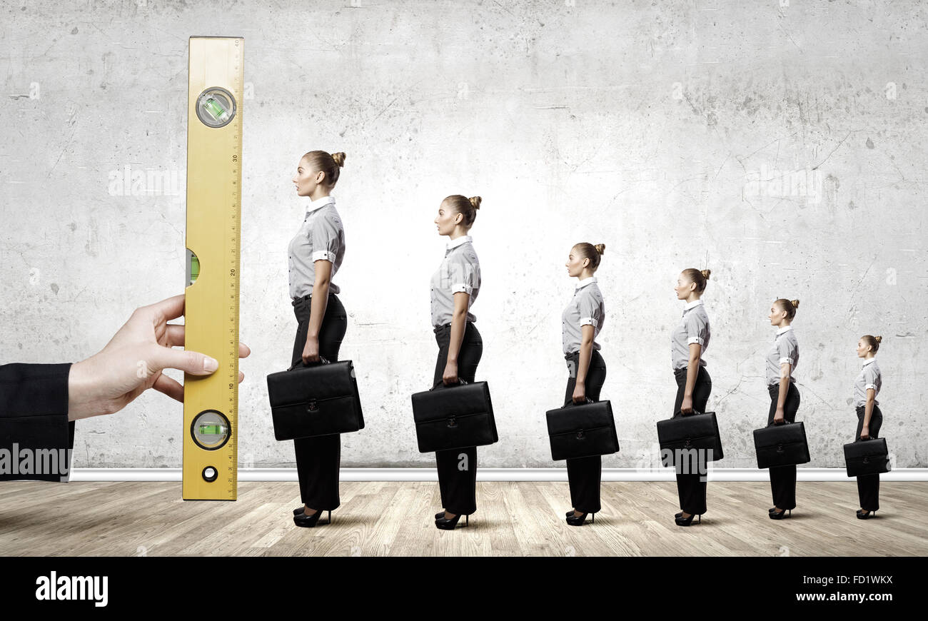 Close up male hand measuring miniatures of businesspeople Stock Photo ...