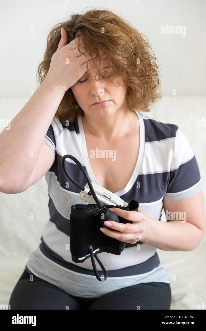 Woman with headache measures a blood pressure Stock Photo - Alamy