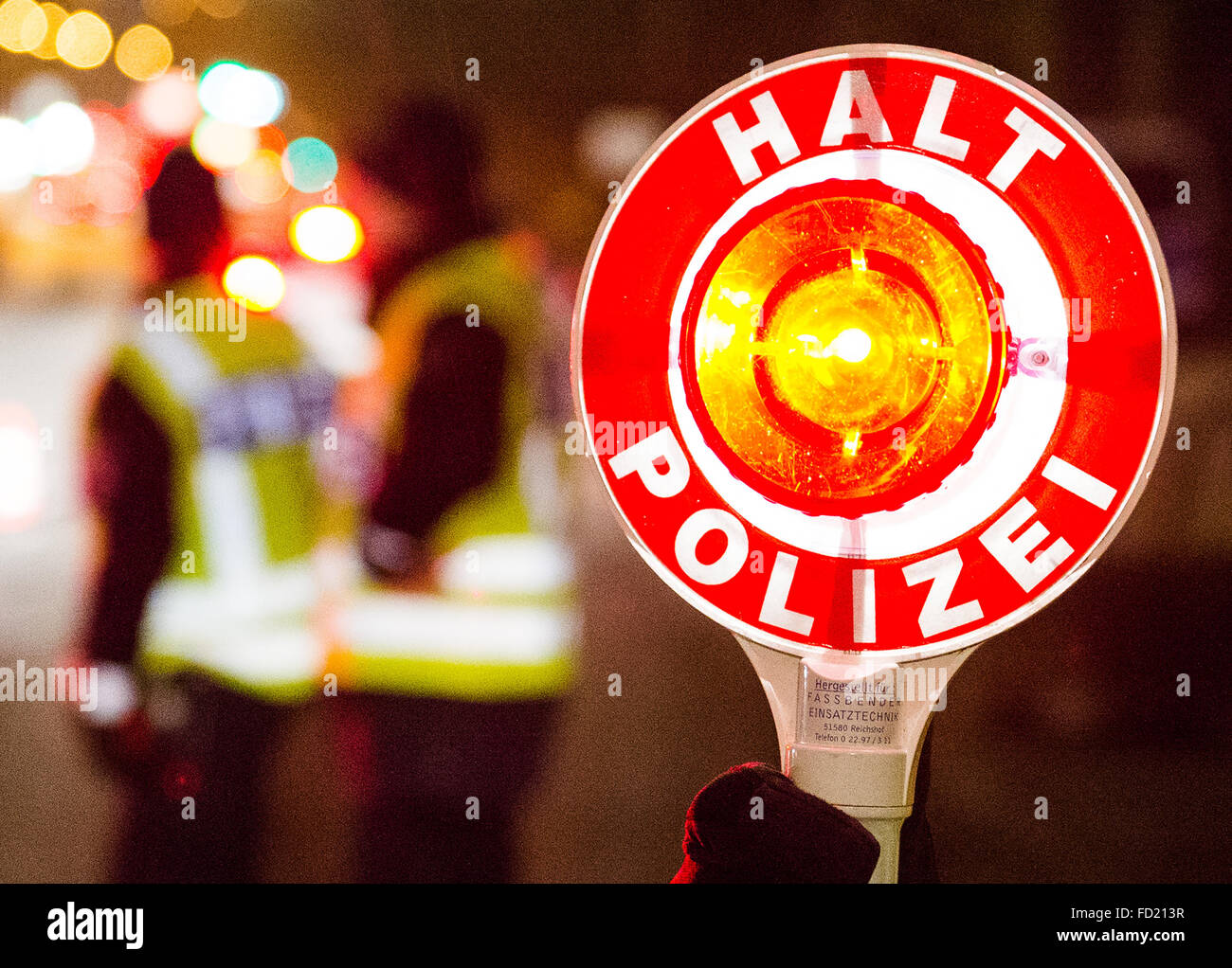 ILLUSTRATION - A police officer holds a red police stop sign which ...