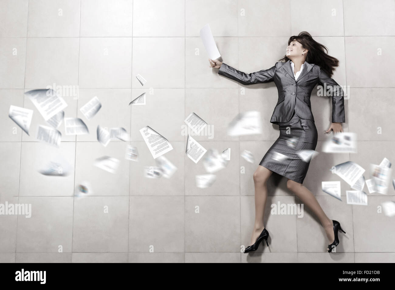 Attractive businesswoman running with papers in hand Stock Photo - Alamy