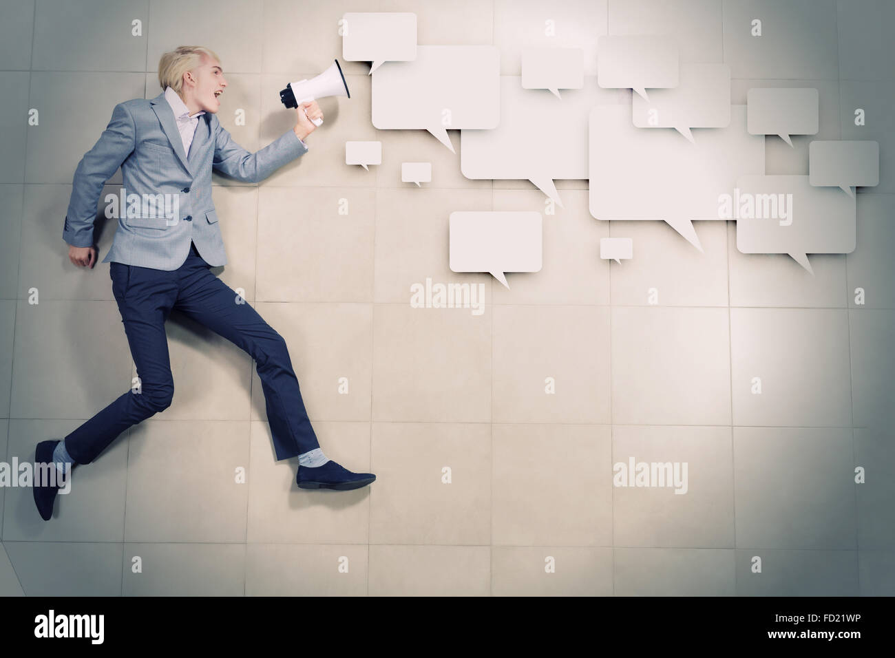 Young businessman running with megaphone in hand Stock Photo - Alamy