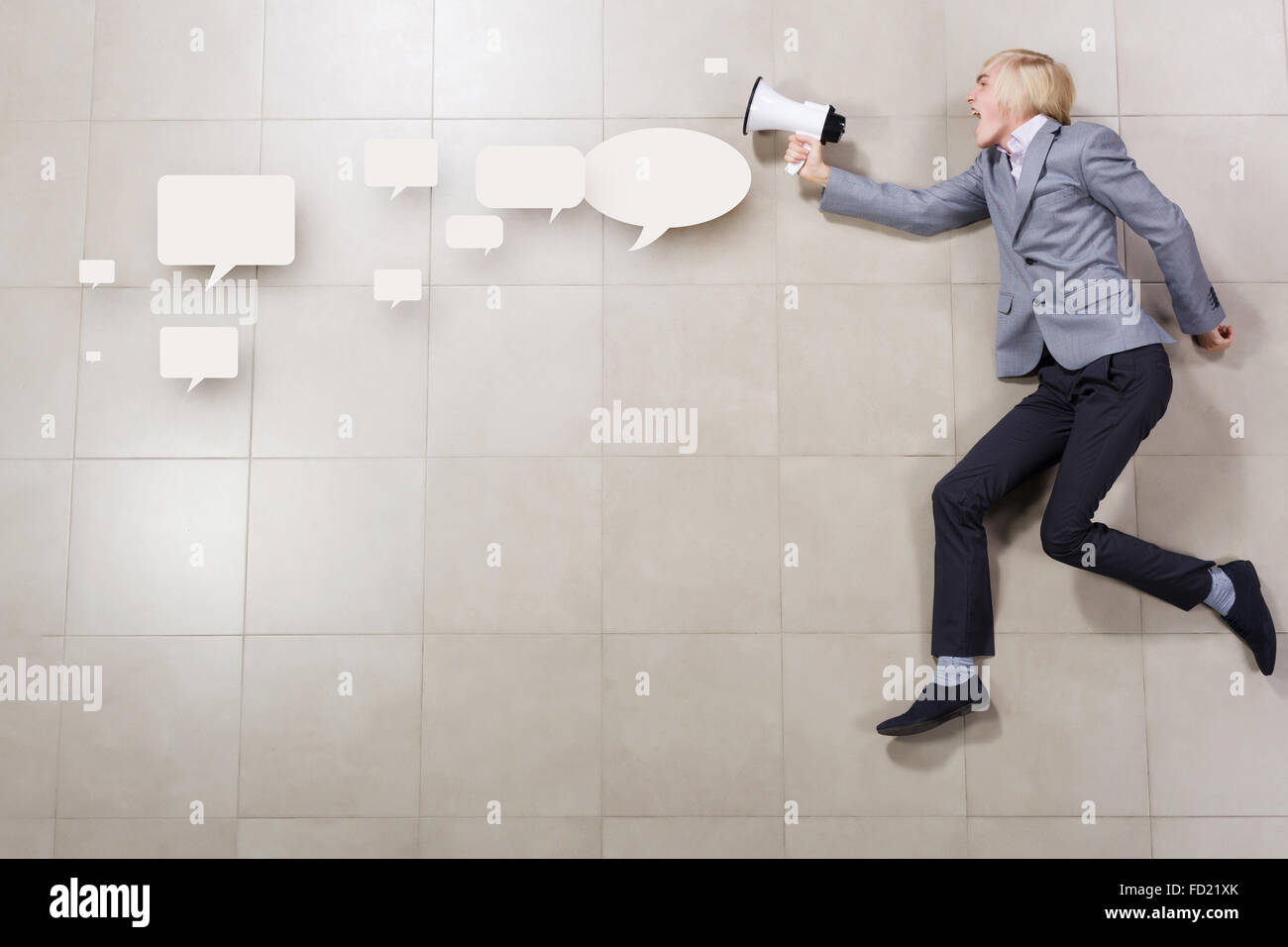 Young businessman running with megaphone in hand Stock Photo - Alamy