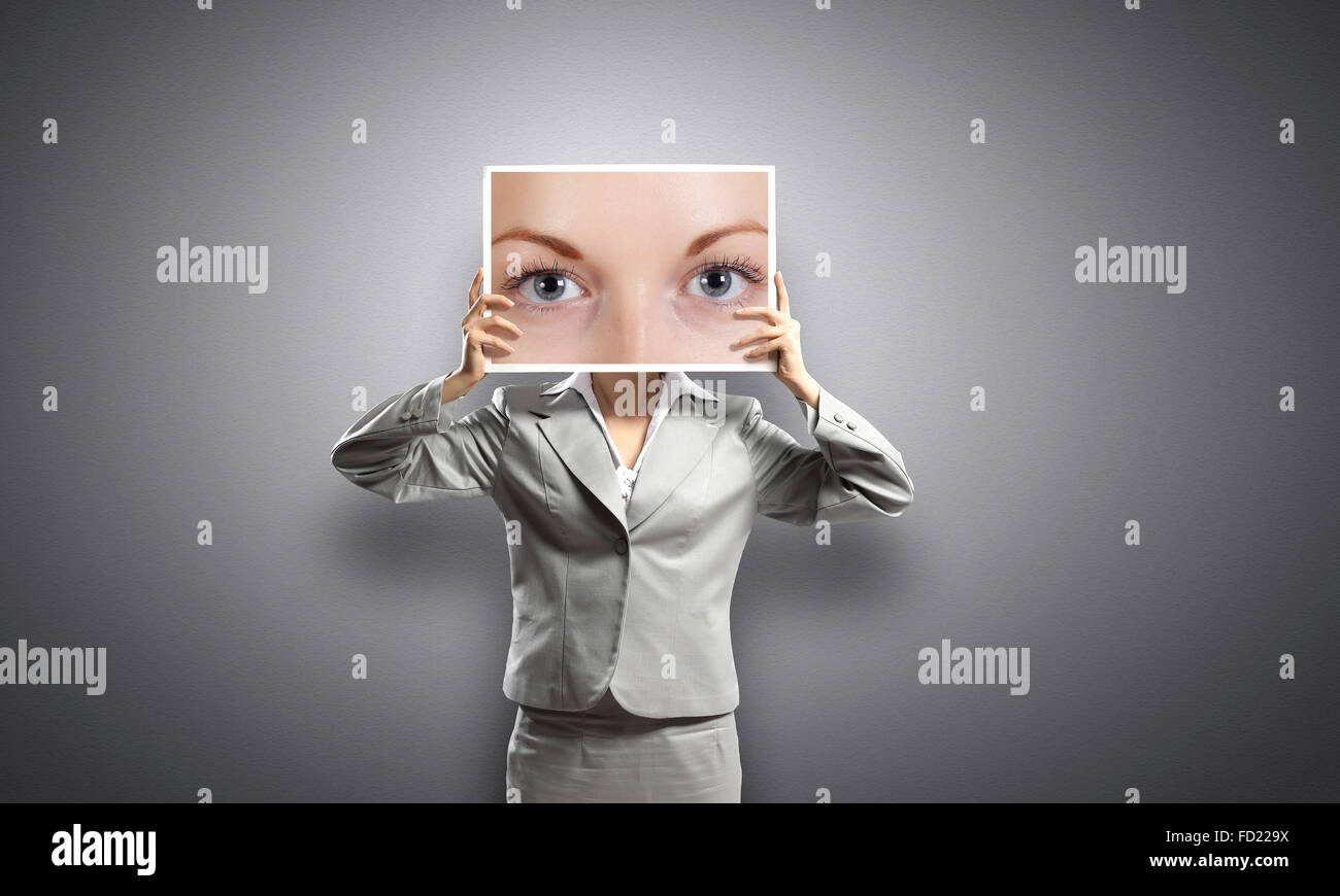 Businesswoman hiding face behind photo of eyes Stock Photo - Alamy