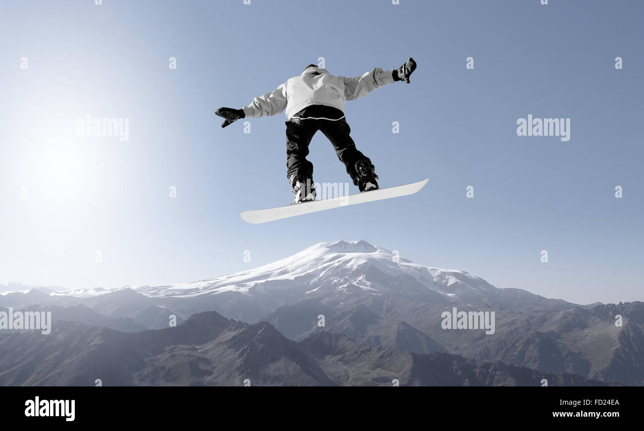 Snowboarder making high jump in clear blue sky Stock Photo - Alamy
