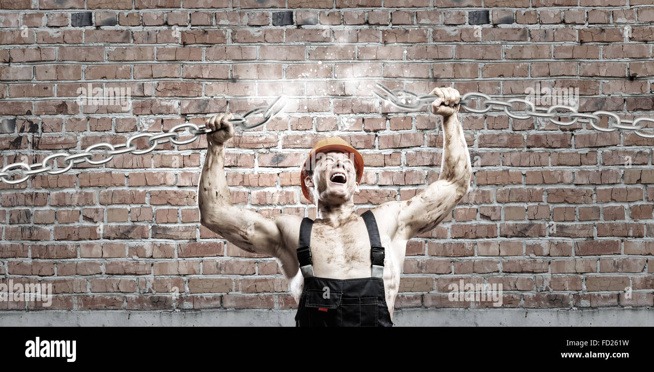 Strong man in uniform tearing metal chain with hands Stock Photo - Alamy