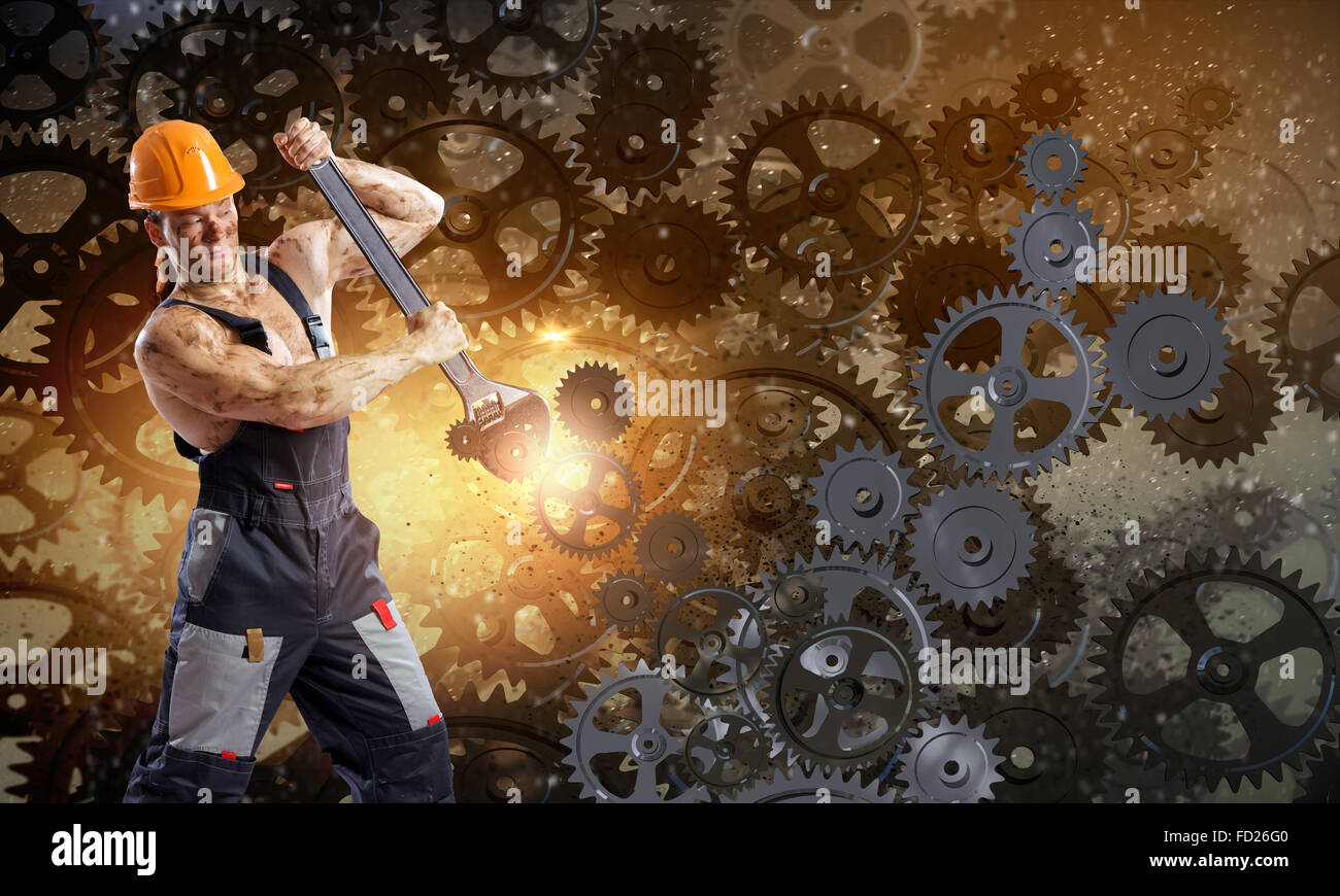 Strong man mechanic in uniform with spanner fixing mechanism Stock ...