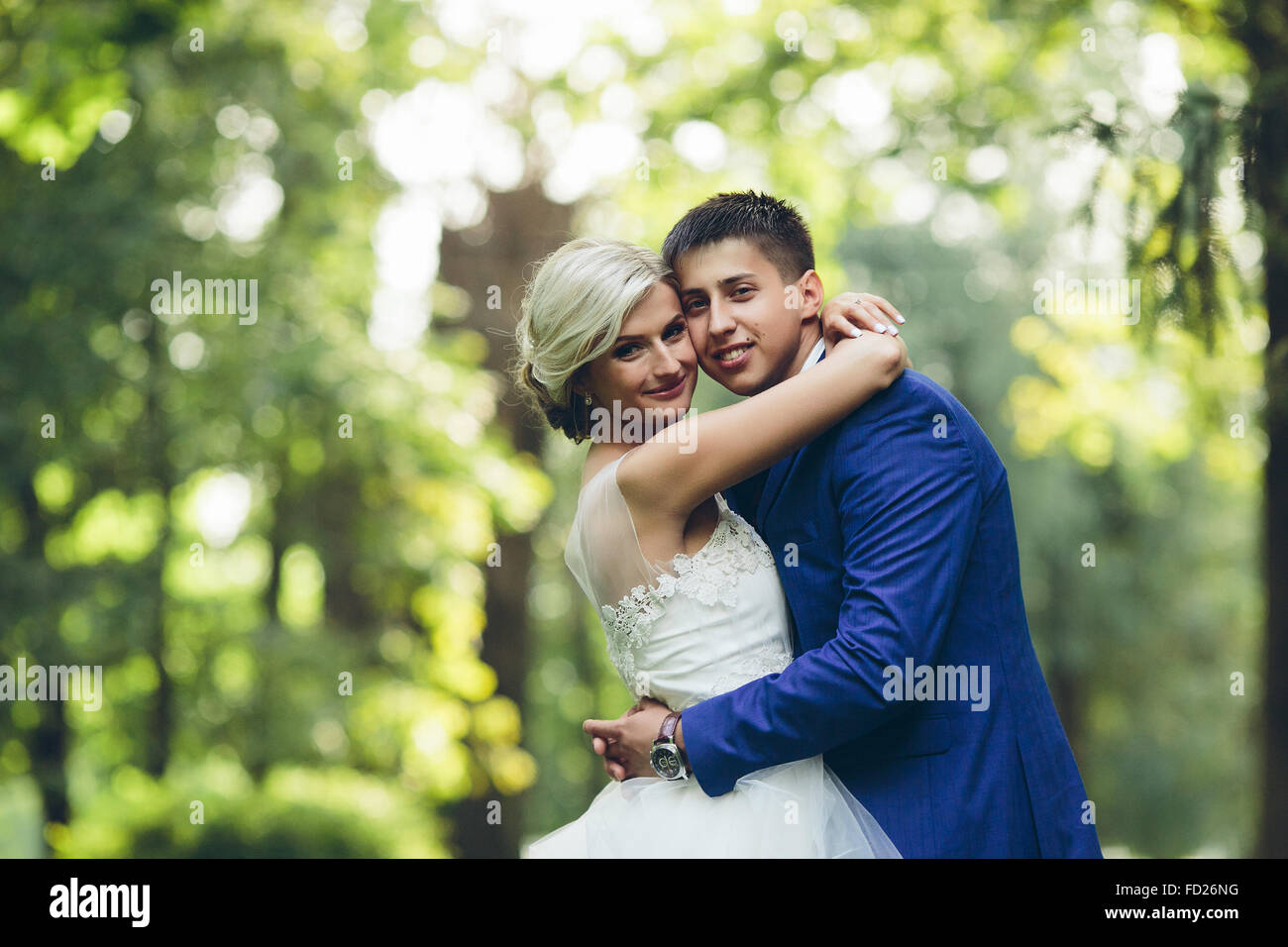 Beautiful wedding couple hugging in the park Stock Photo - Alamy