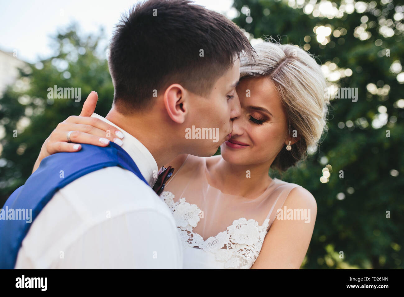 Beautiful wedding couple hugging in the park Stock Photo - Alamy