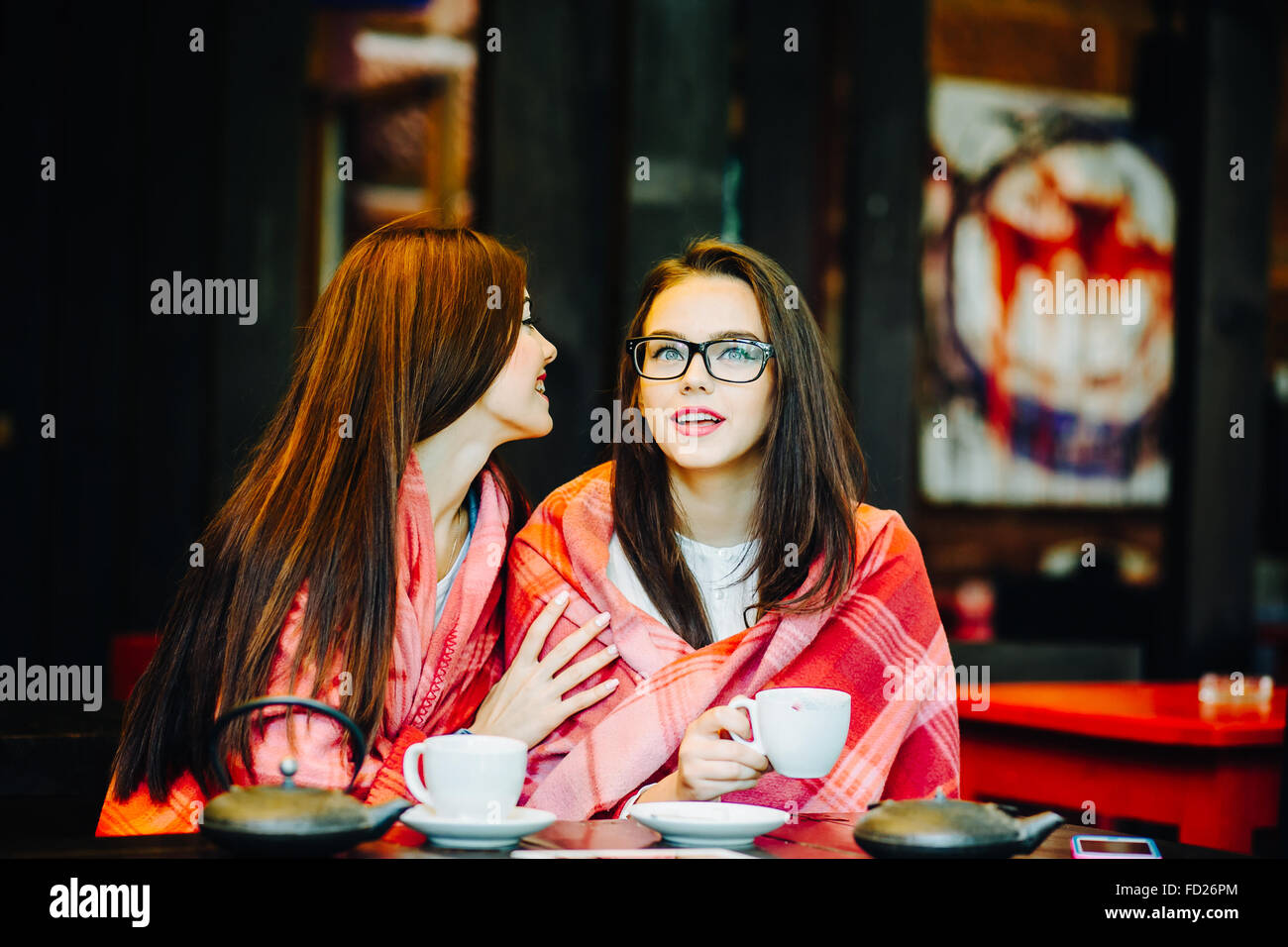 Two young and beautiful girls gossiping Stock Photo - Alamy
