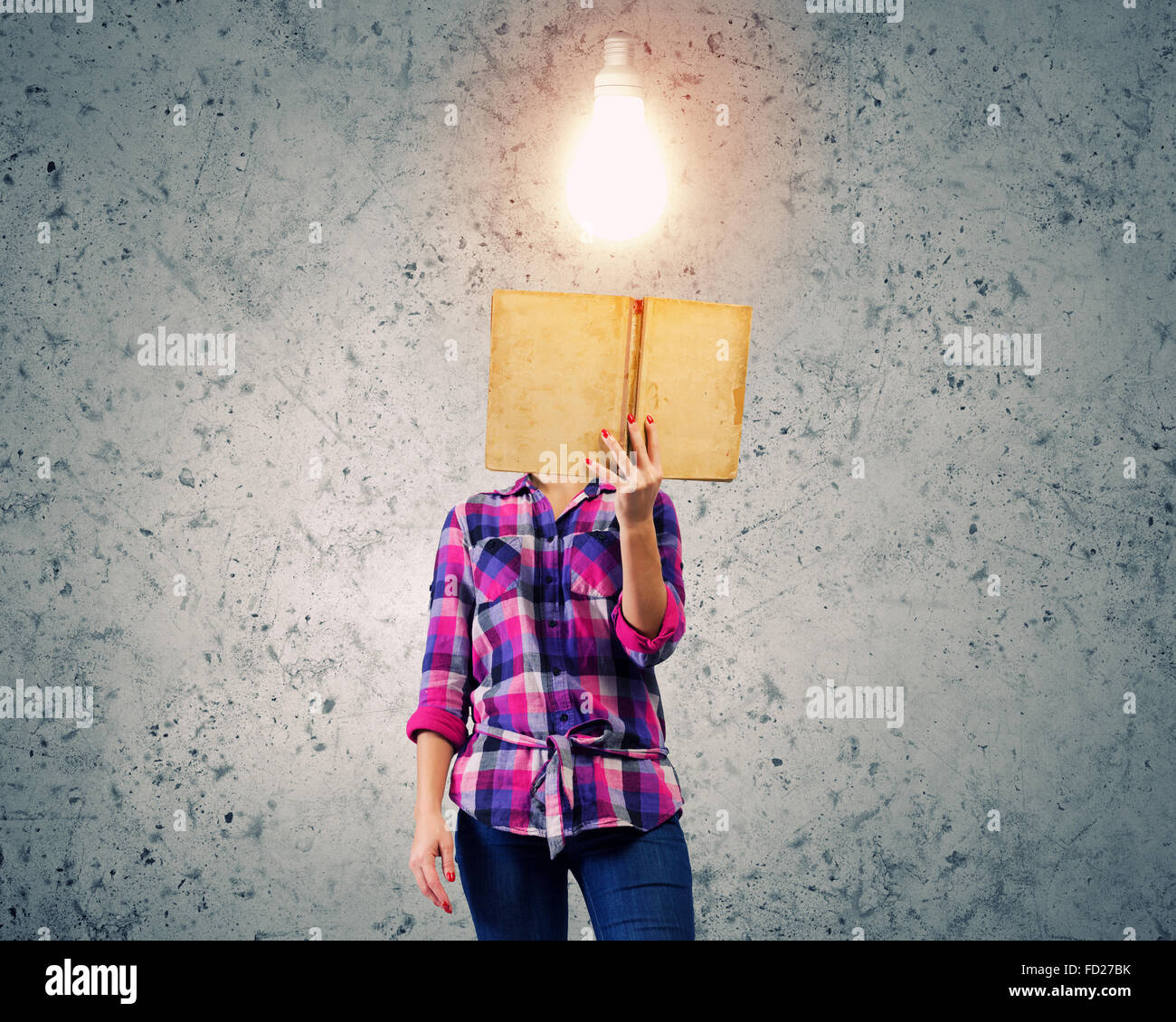 Young woman in casual hiding face behind reading Stock Photo - Alamy