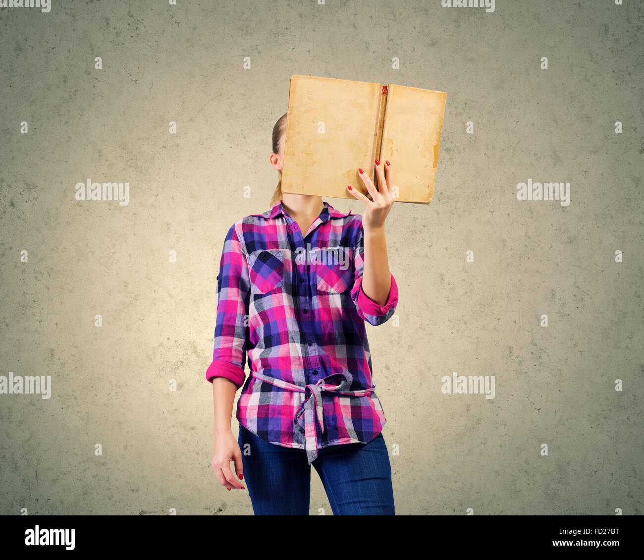 Young woman in casual hiding face behind reading Stock Photo - Alamy