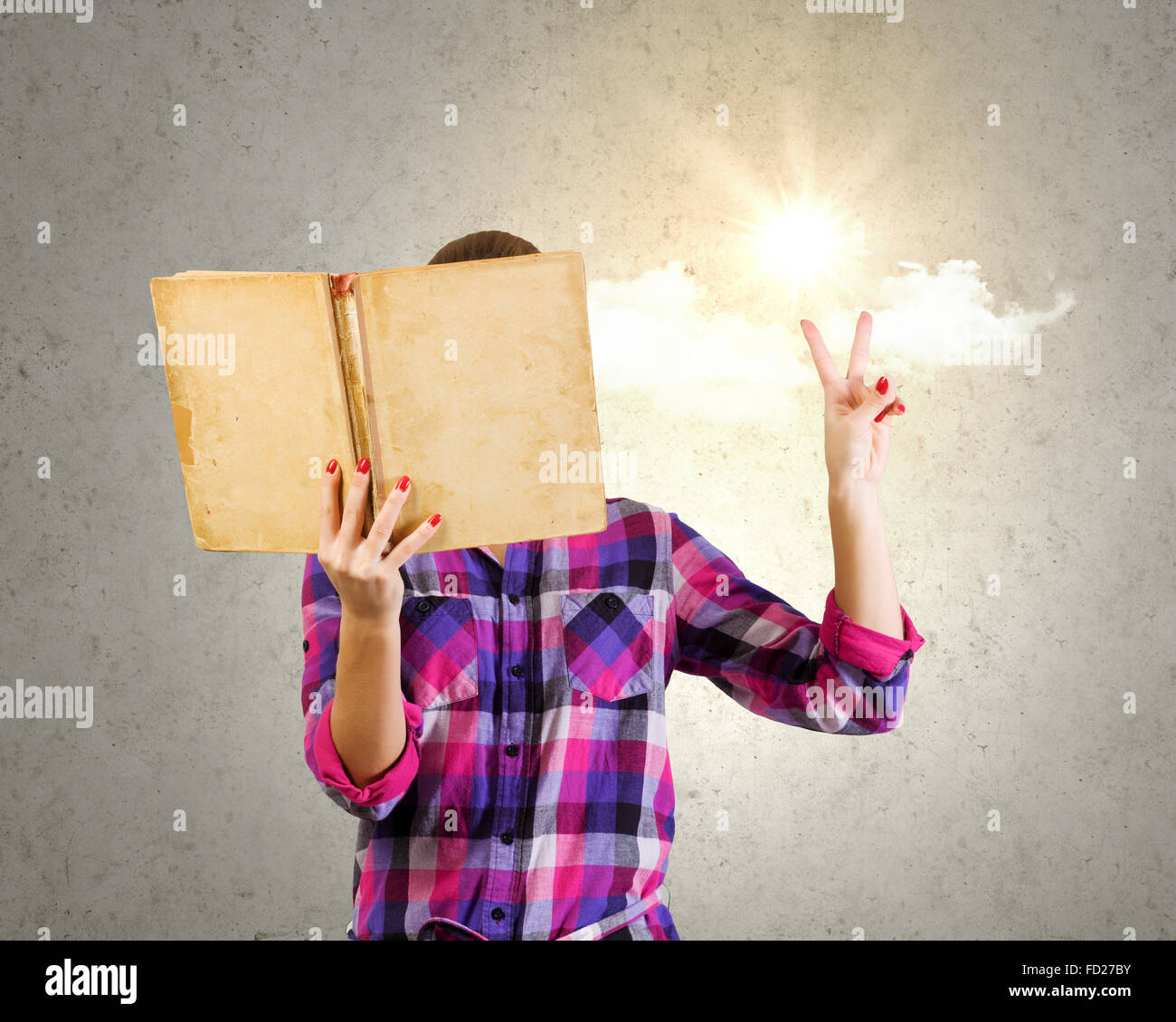 Young woman in casual hiding face behind reading Stock Photo - Alamy