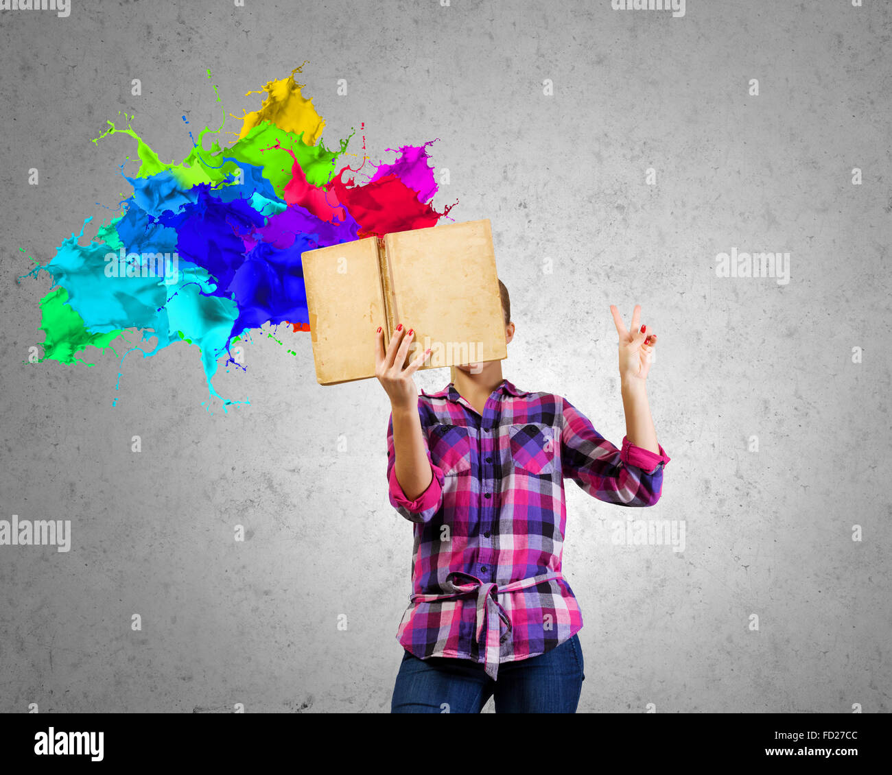 Young woman in casual hiding face behind reading Stock Photo - Alamy