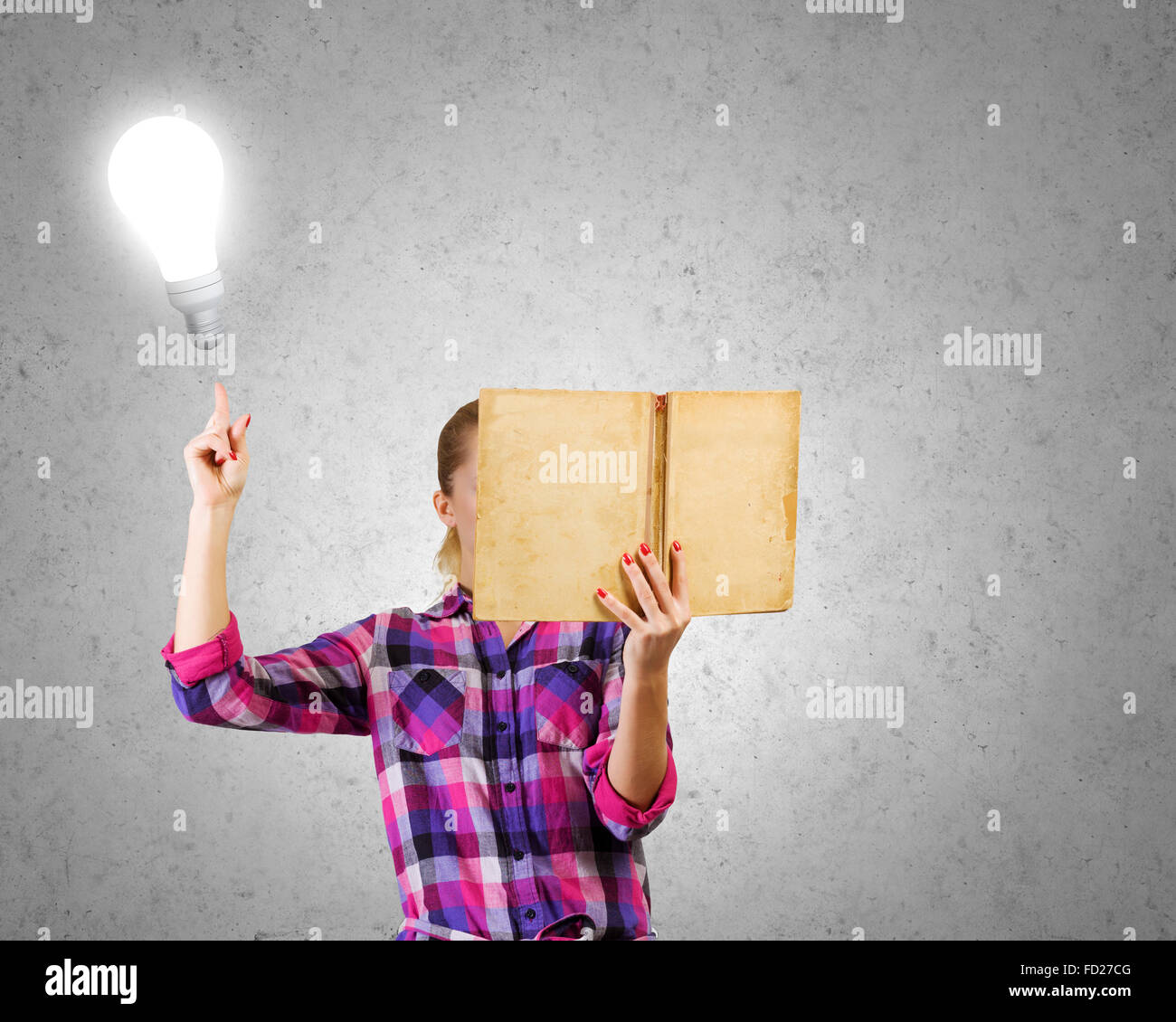 Young woman in casual hiding face behind reading Stock Photo - Alamy