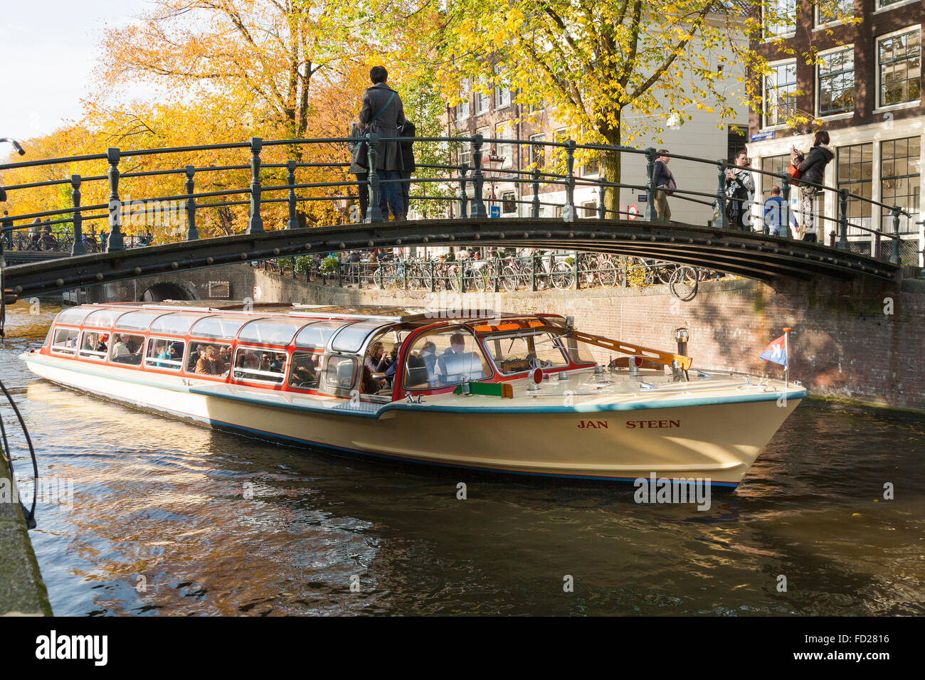 Tourist boat / barge passing under a canal bridge Autumn / fall with ...