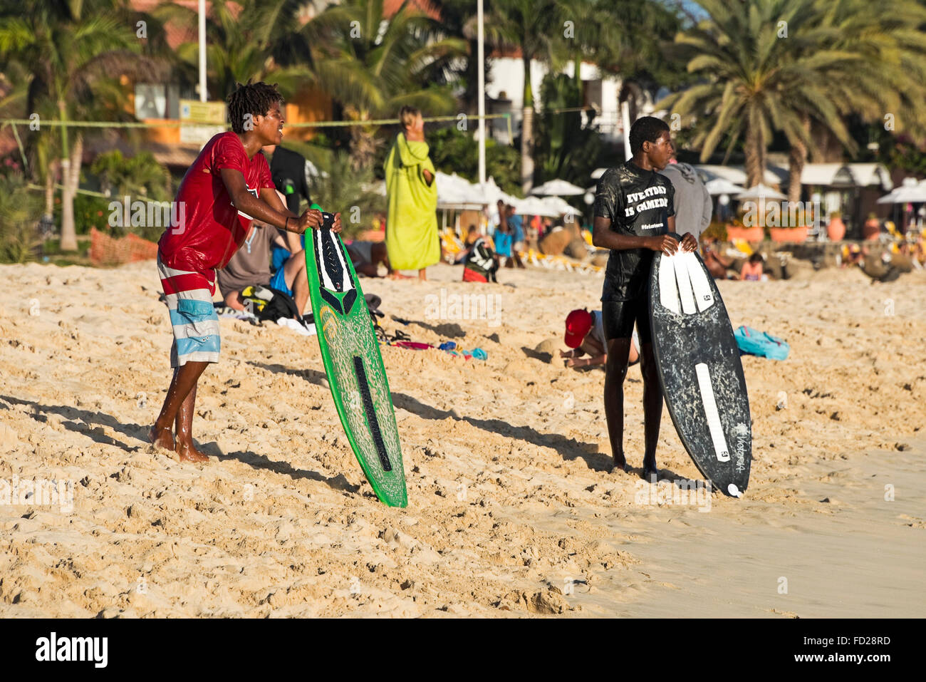Horizontal portrait of skim boarders standing on the beach waiting for ...