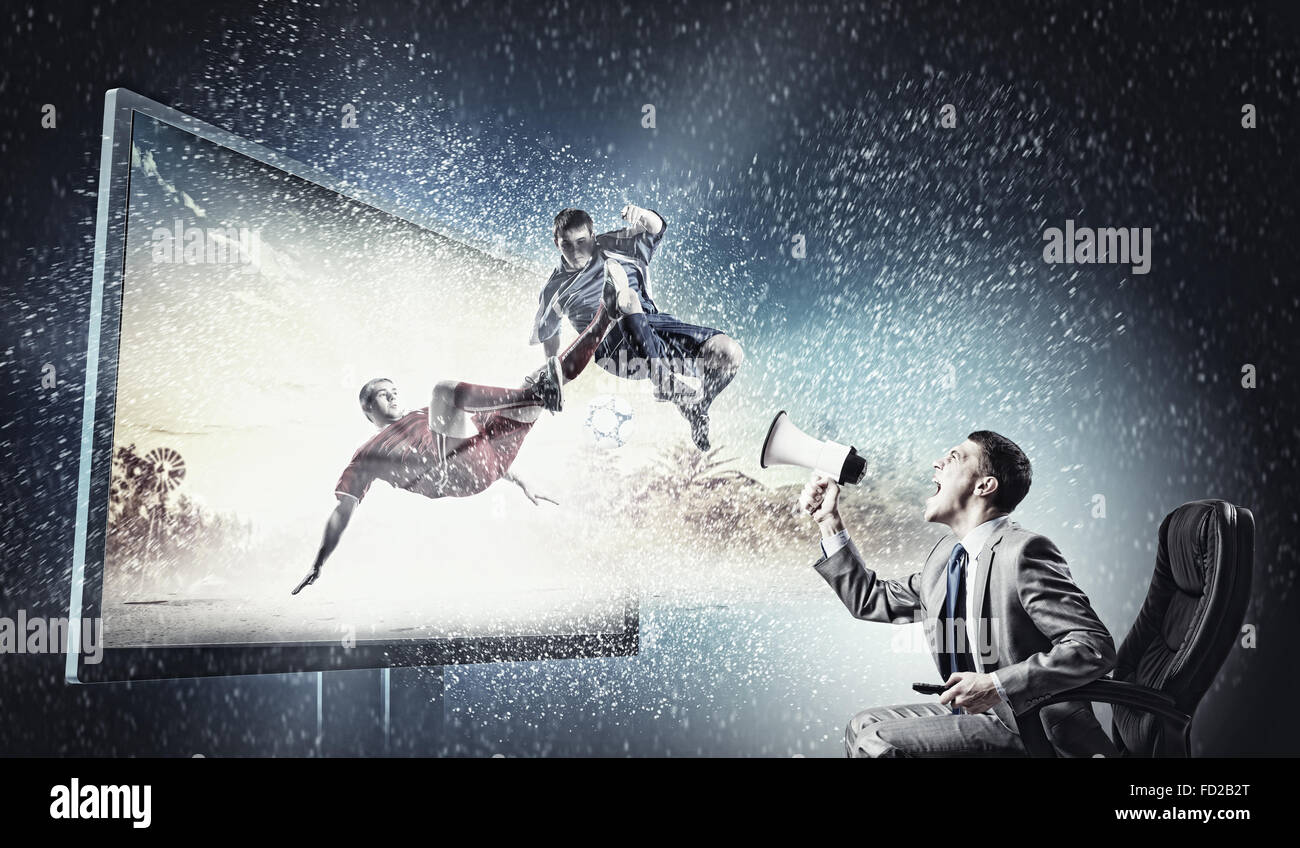 Young man screaming in megaphone and watching football match Stock ...