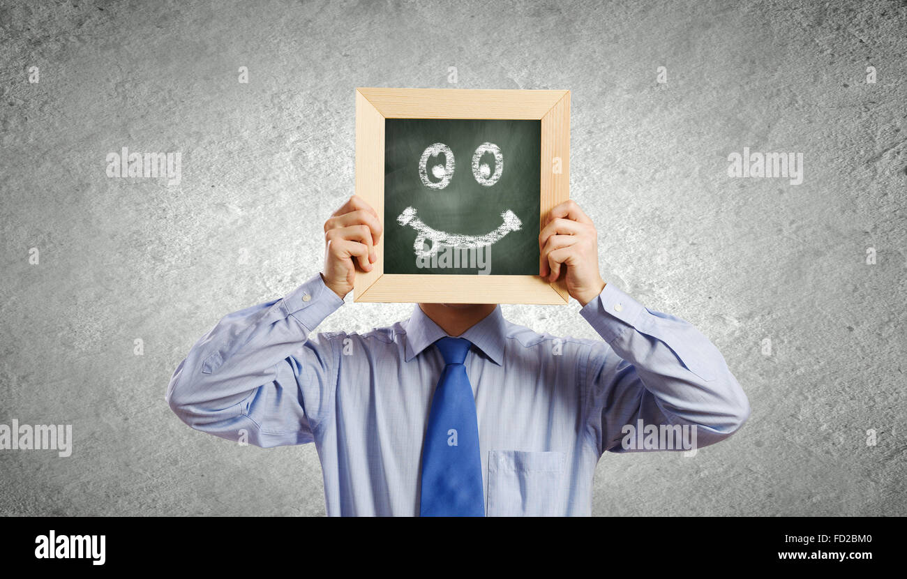 Young smiling businessman holding chalkboard with smiley hi-res stock ...