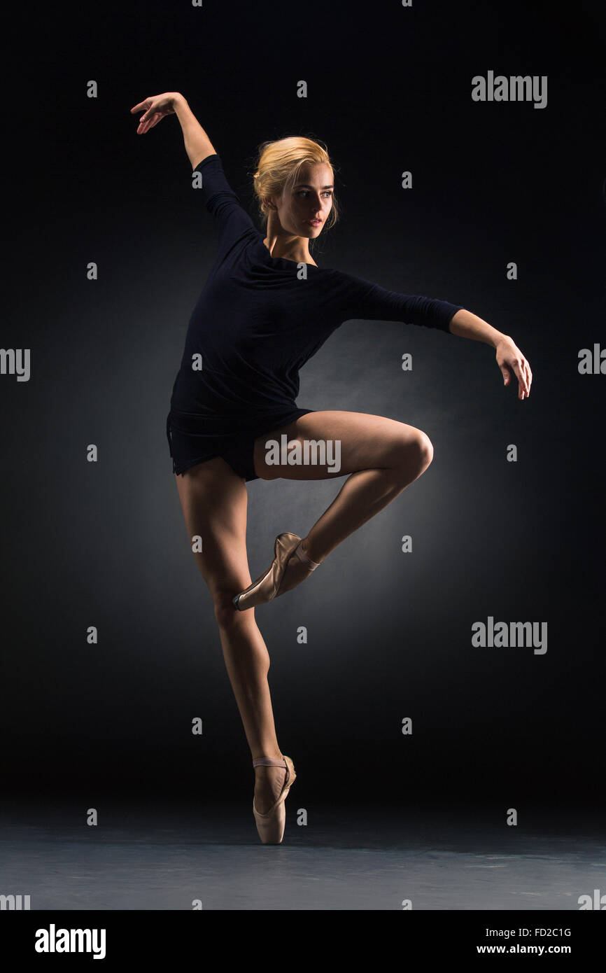young beautiful modern style dancer posing on a studio gray background ...