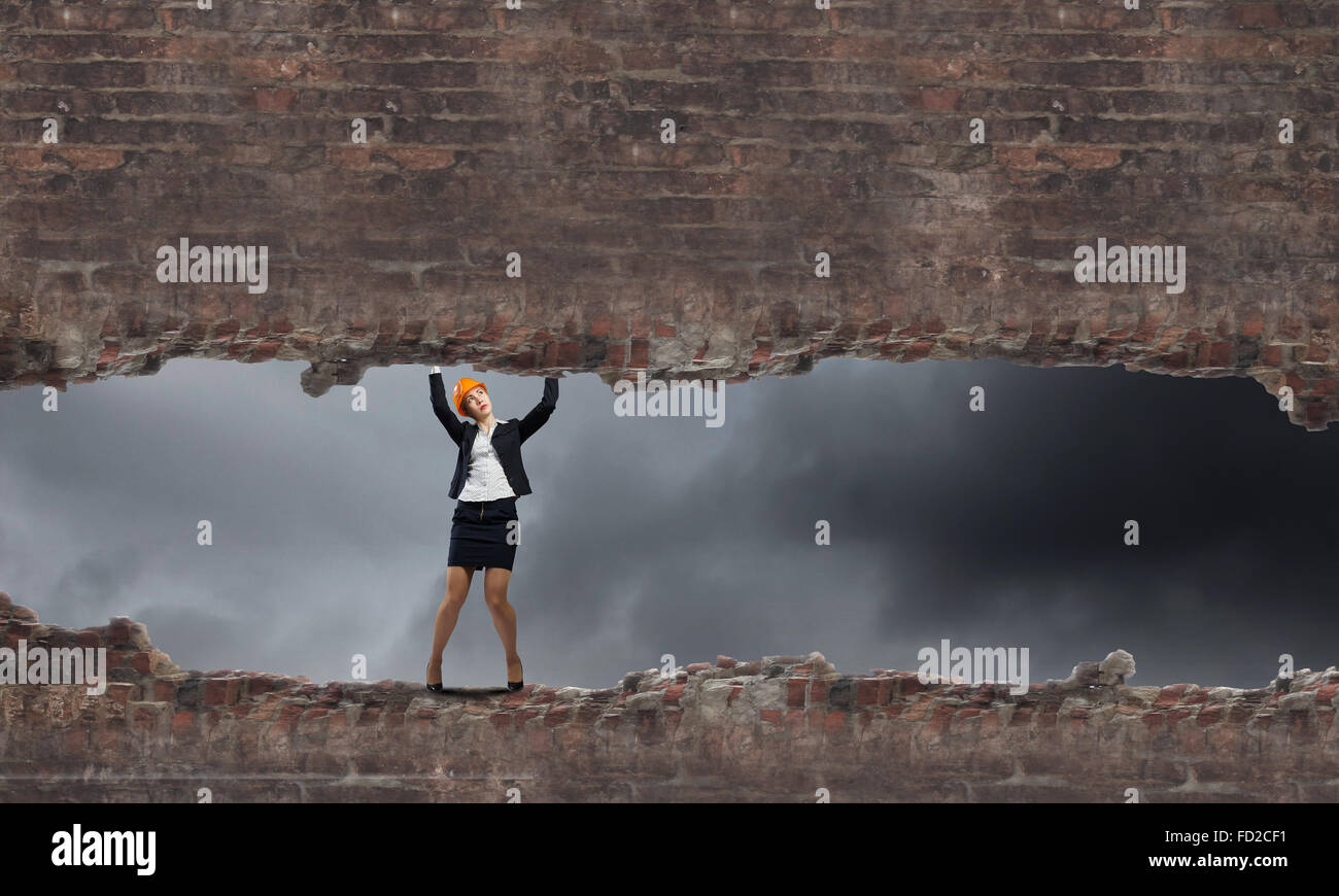 Young engineer woman lifting brick wall above head Stock Photo - Alamy