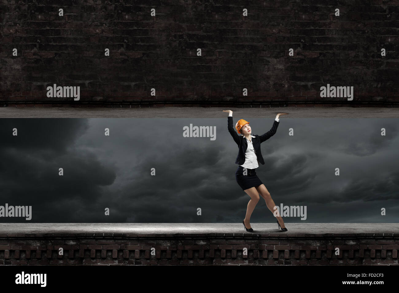 Young engineer woman lifting brick wall above head Stock Photo - Alamy