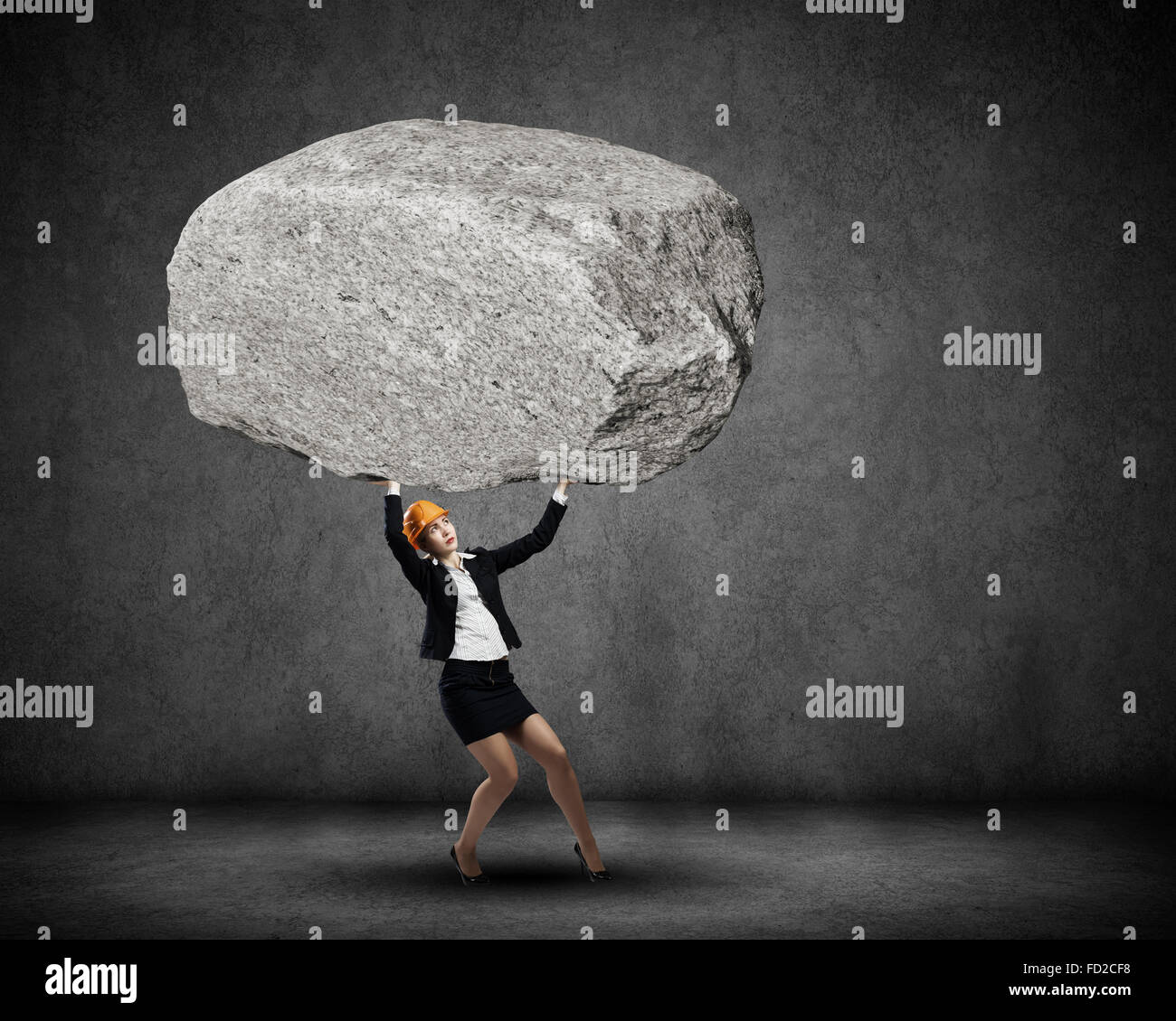 Young woman engineer lifting huge stone above head Stock Photo - Alamy