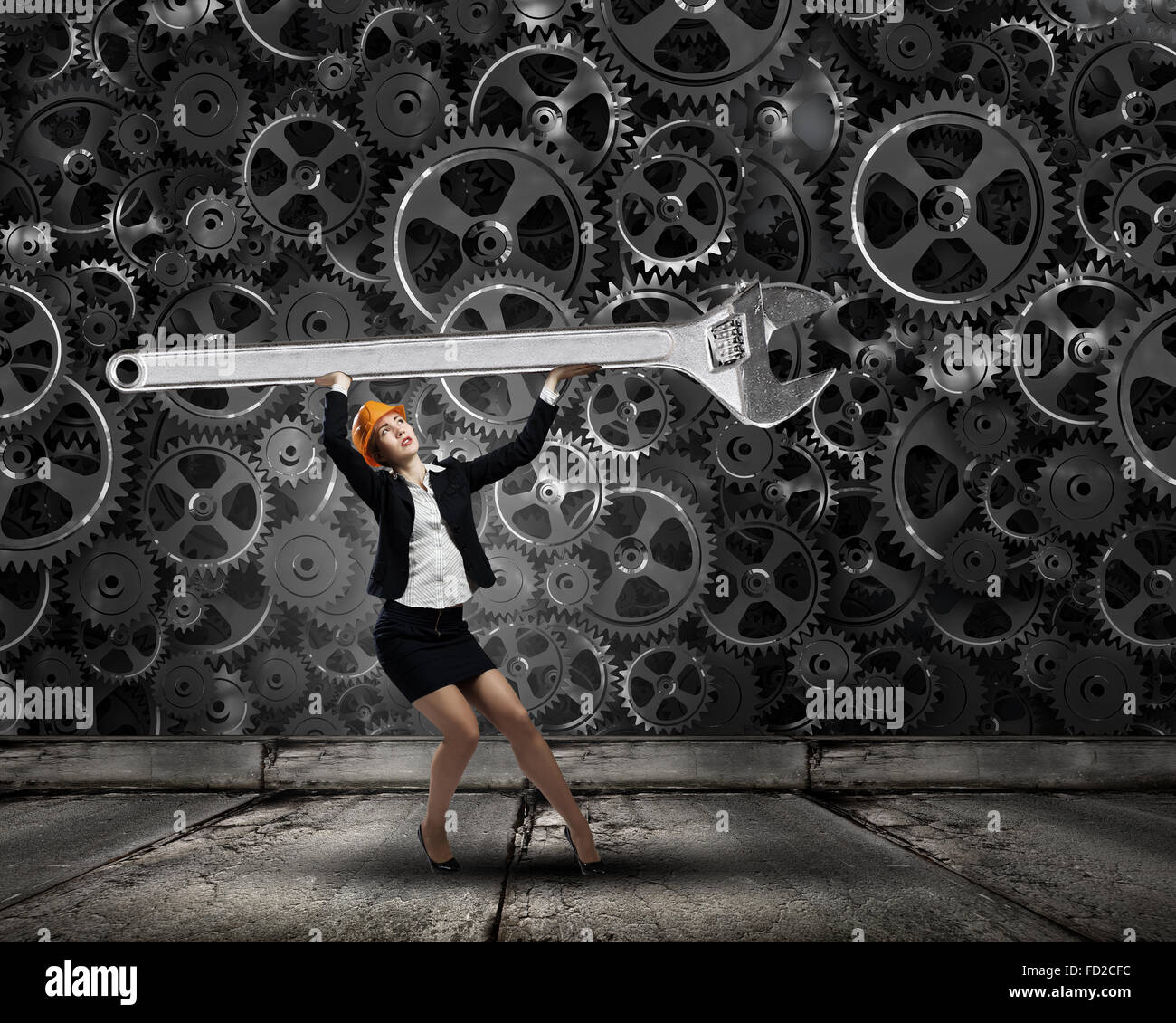 Young woman engineer holding huge wrench above head Stock Photo - Alamy