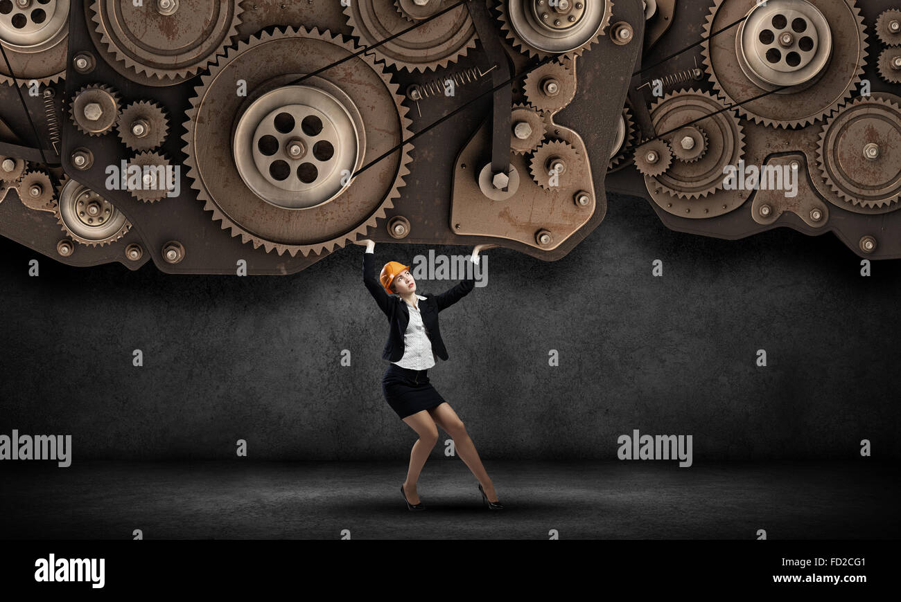 Young woman engineer holding mechanism of cogwheels above head Stock ...