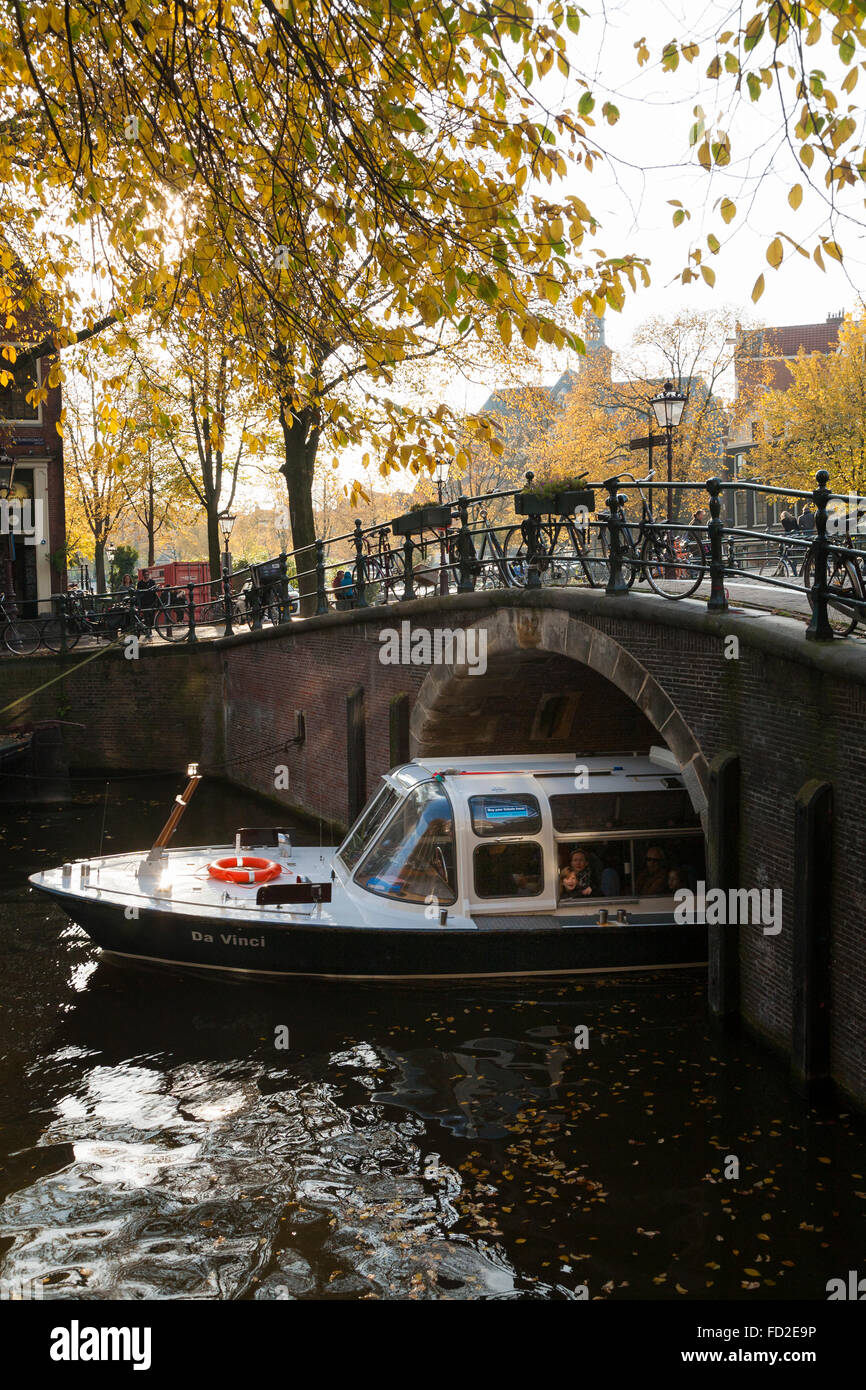 Tourist boat / barge passing under a canal bridge Autumn / fall with ...