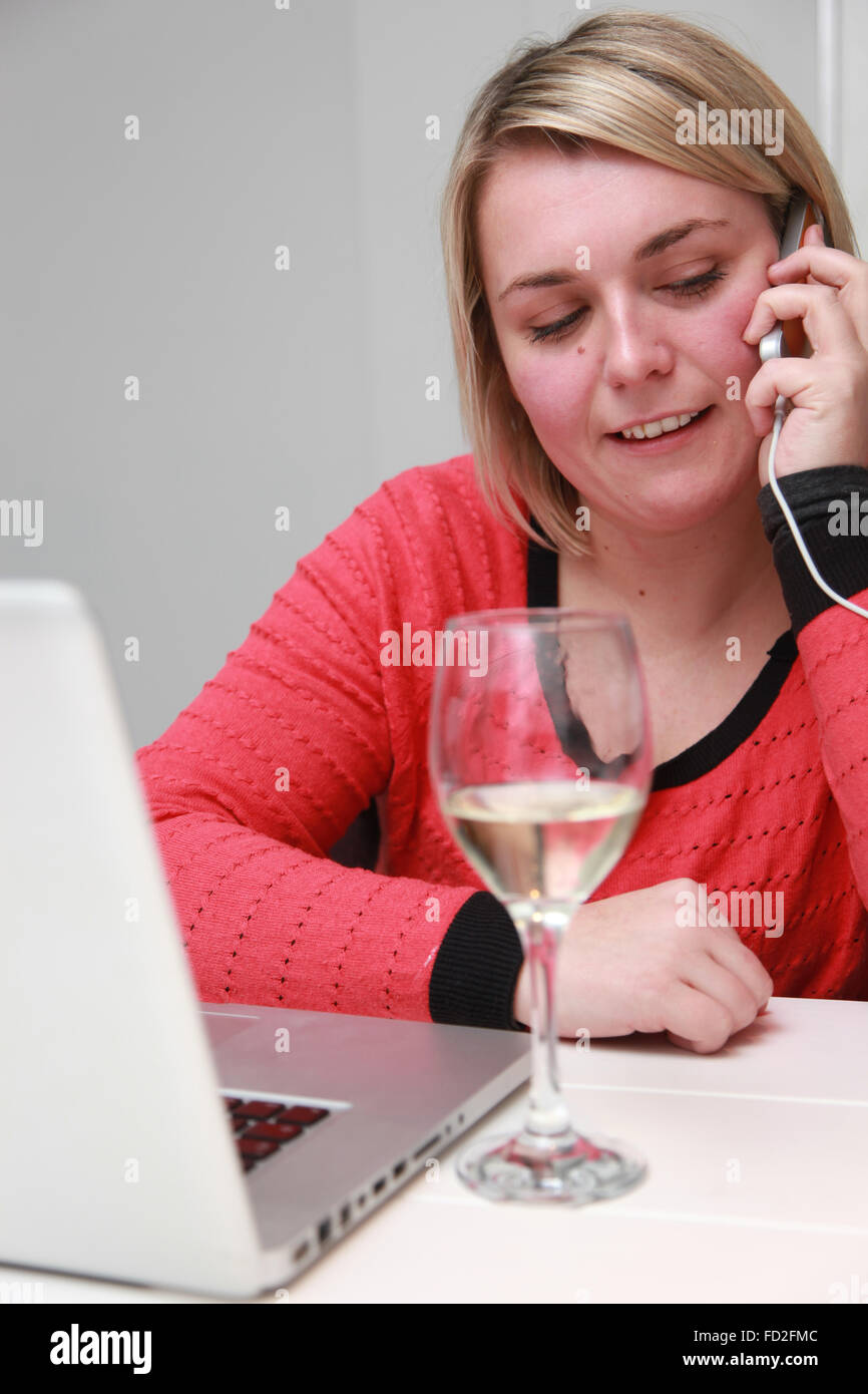 Woman on the phone while working on her laptop Stock Photo - Alamy