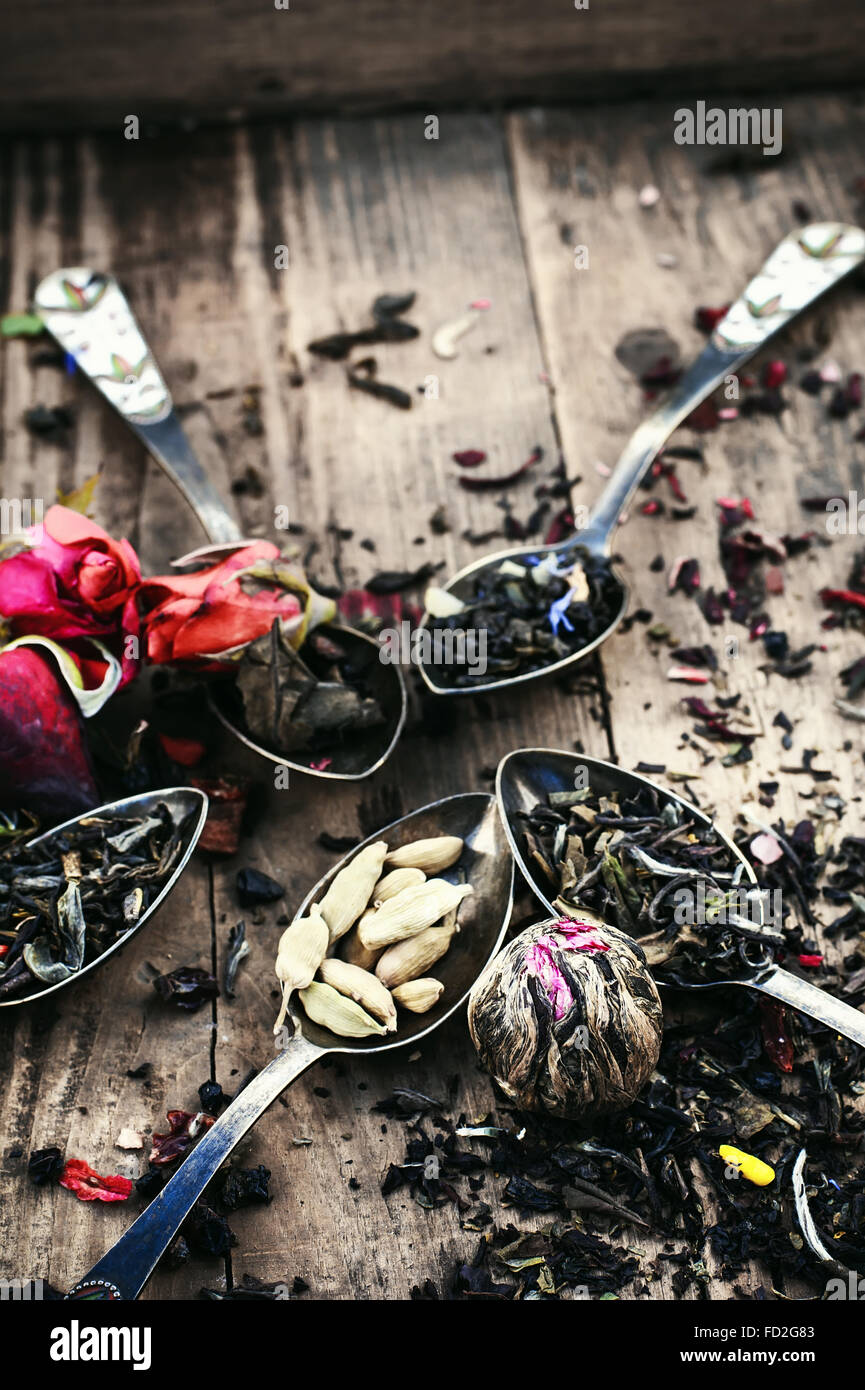 Spoon and spilling the tea leaves of different varieties on retro ...