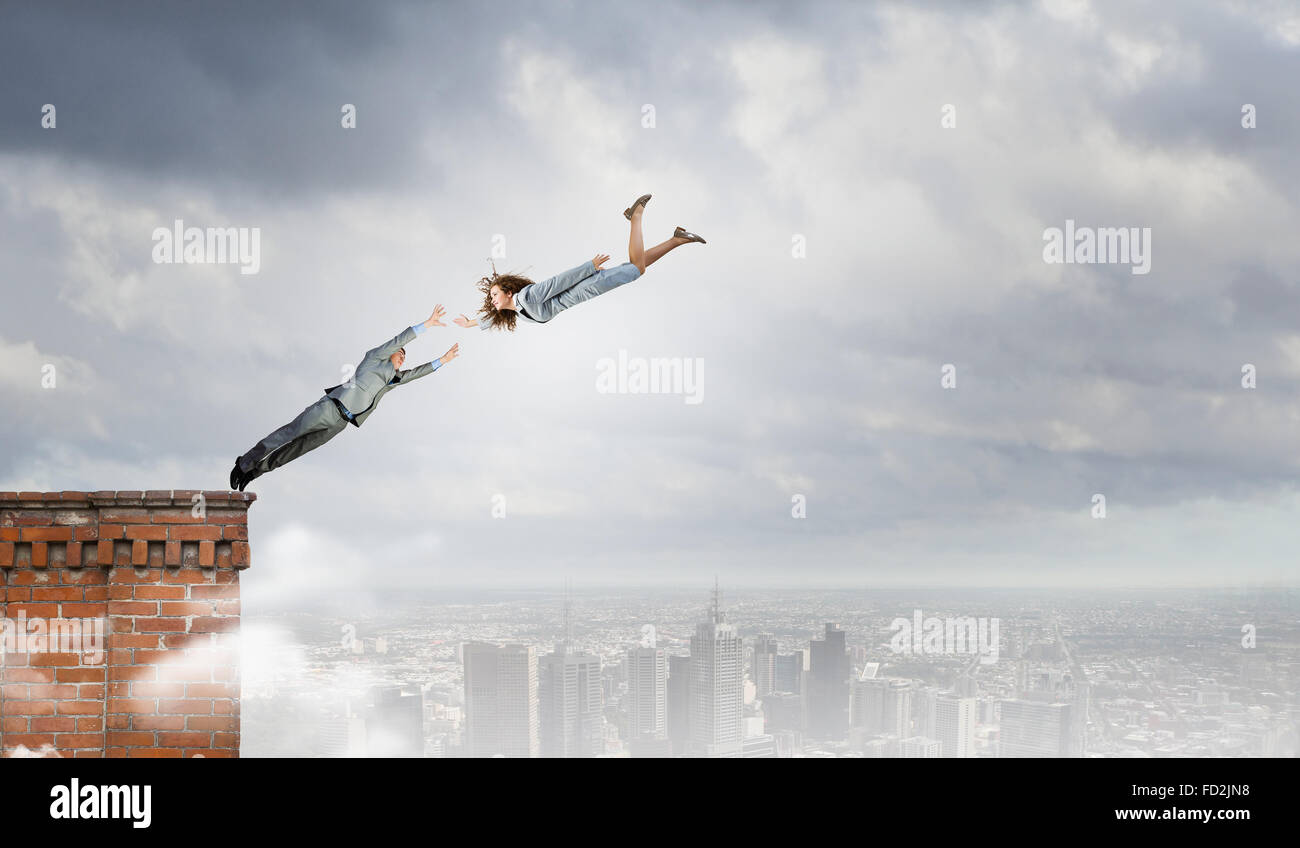 Two young business people flying in sky Stock Photo - Alamy