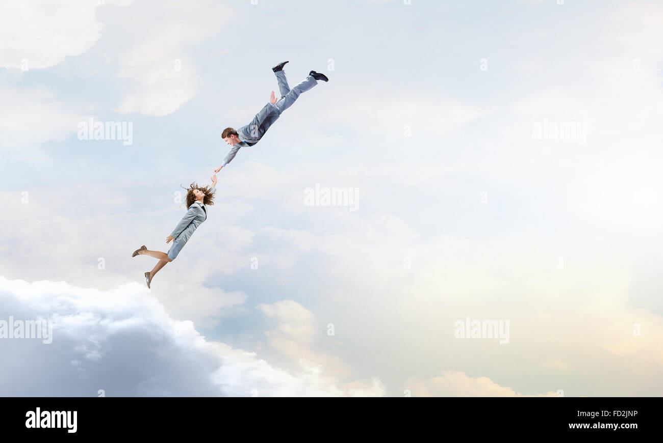 Two young business people flying in sky Stock Photo - Alamy