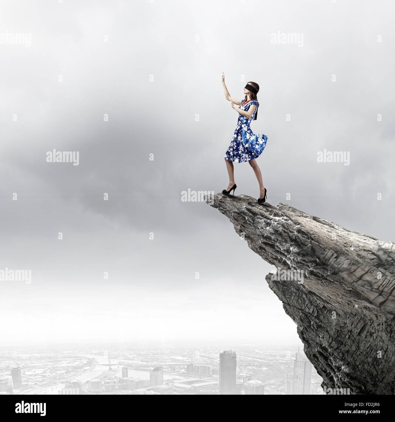 Young woman in blue dress standing on mountain edge Stock Photo - Alamy