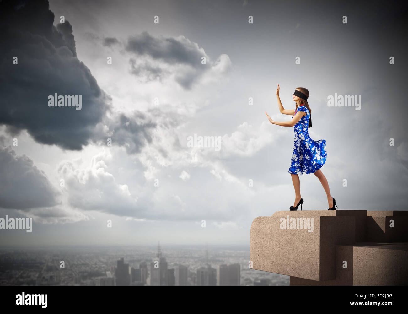 Young woman in blue dress standing on roof edge Stock Photo - Alamy