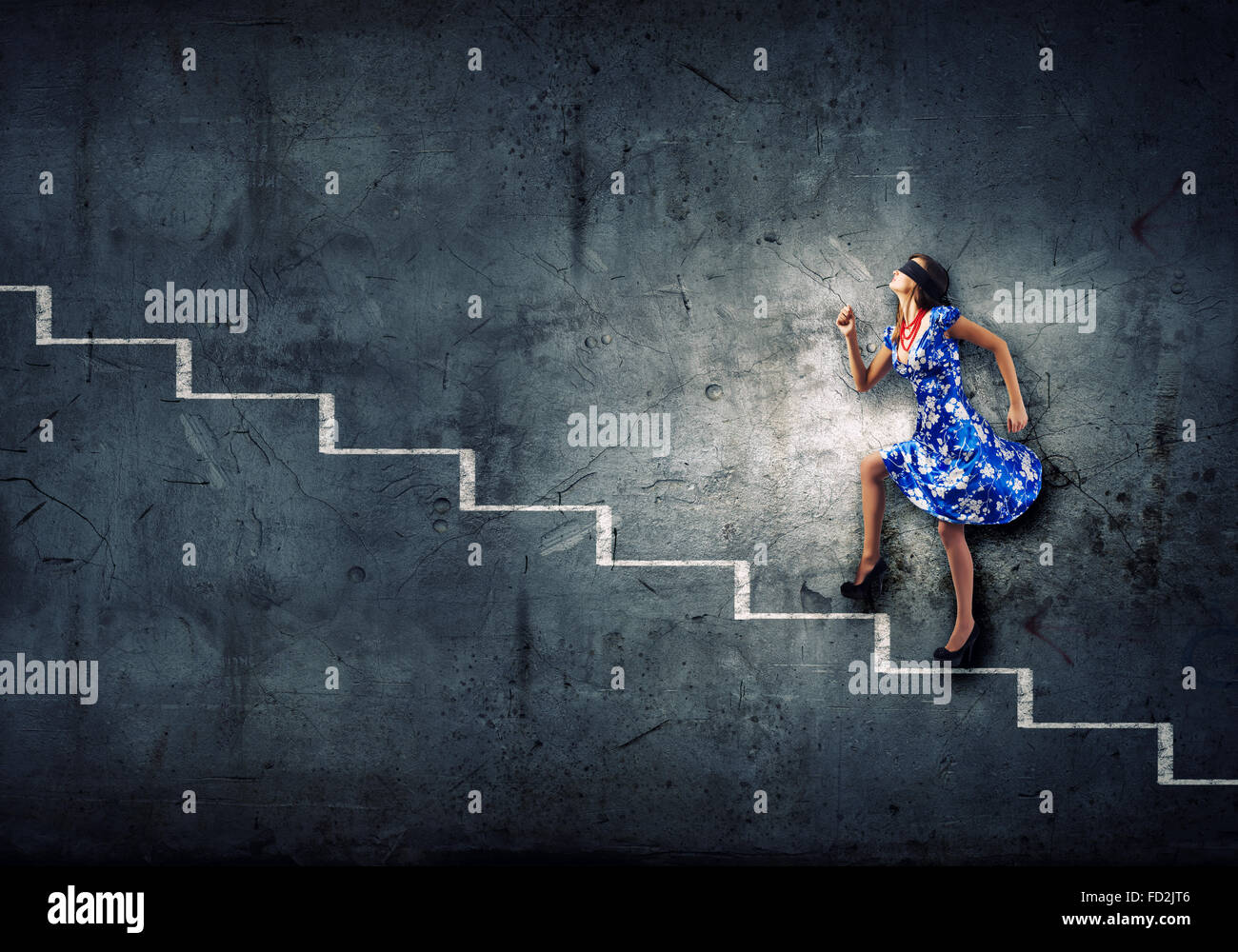 Young woman in blue dress walking on ladder Stock Photo - Alamy