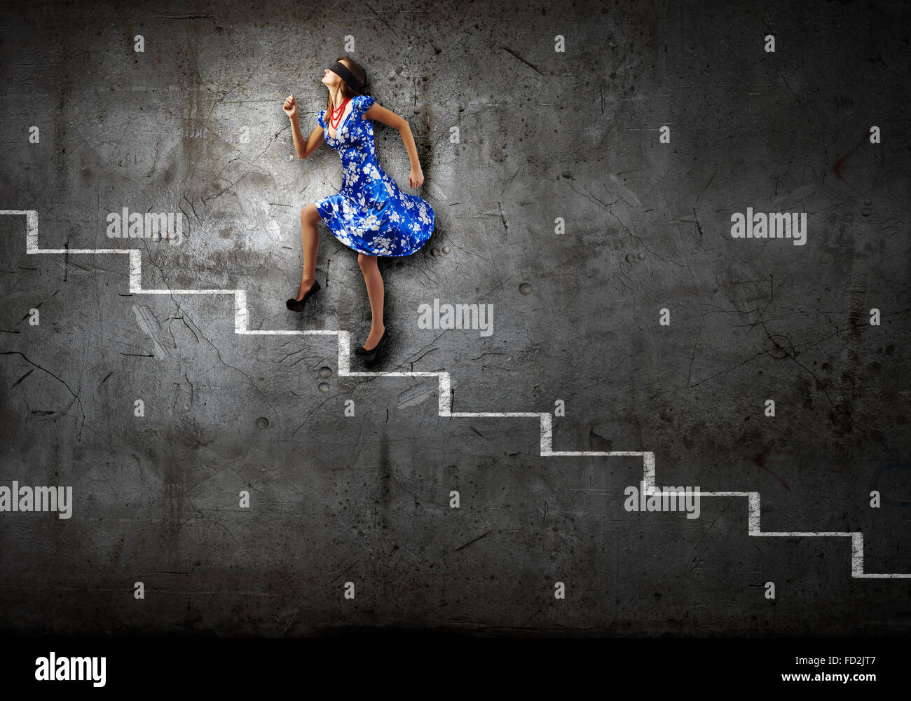 Young woman in blue dress walking on ladder Stock Photo - Alamy