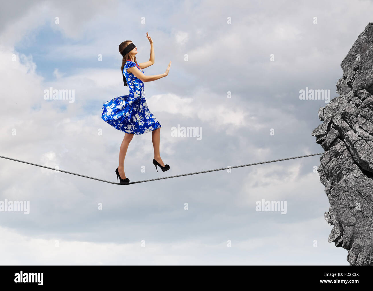 Young woman in blue dress standing on mountain edge Stock Photo - Alamy