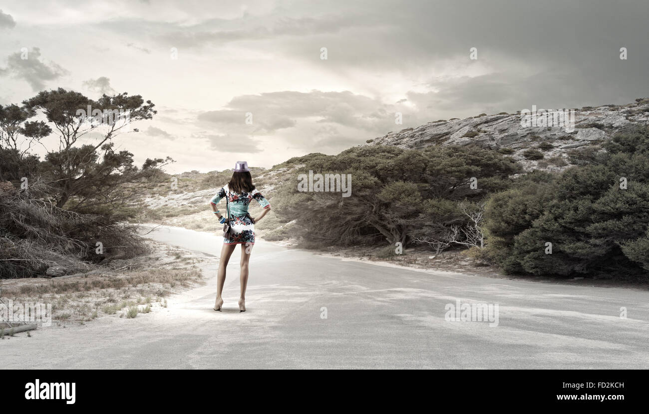 Rear view of young woman standing aside of road Stock Photo - Alamy
