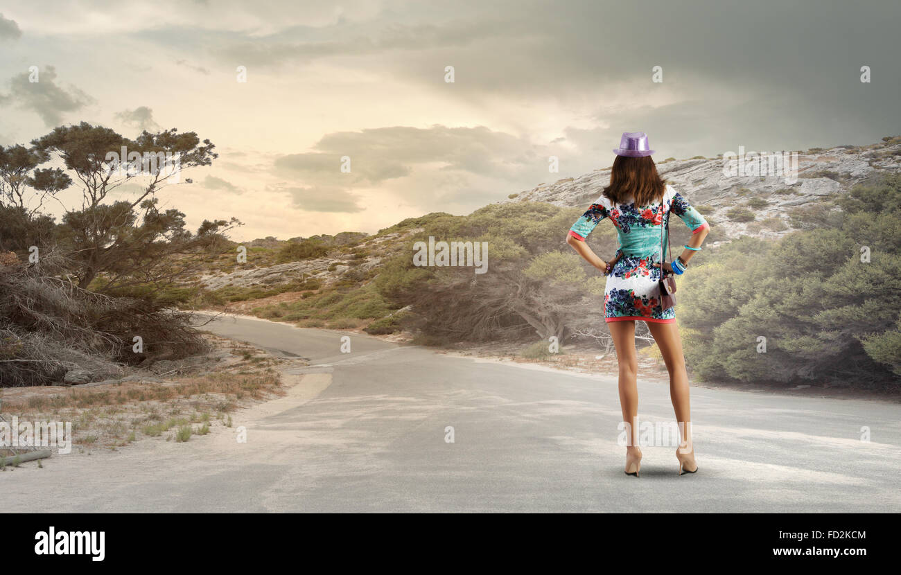 Rear view of young woman standing aside of road Stock Photo - Alamy