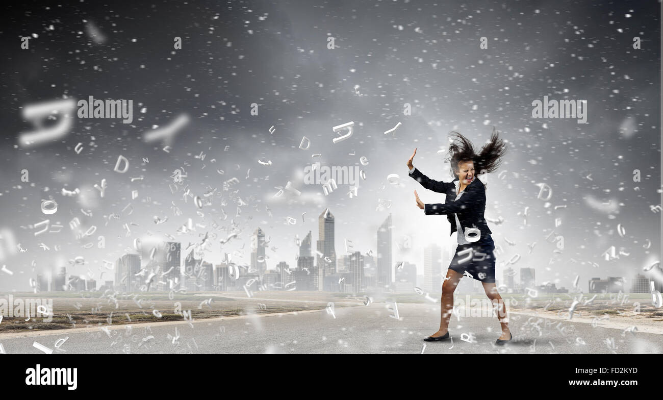 Young determined businesswoman walking against strong wind Stock Photo ...