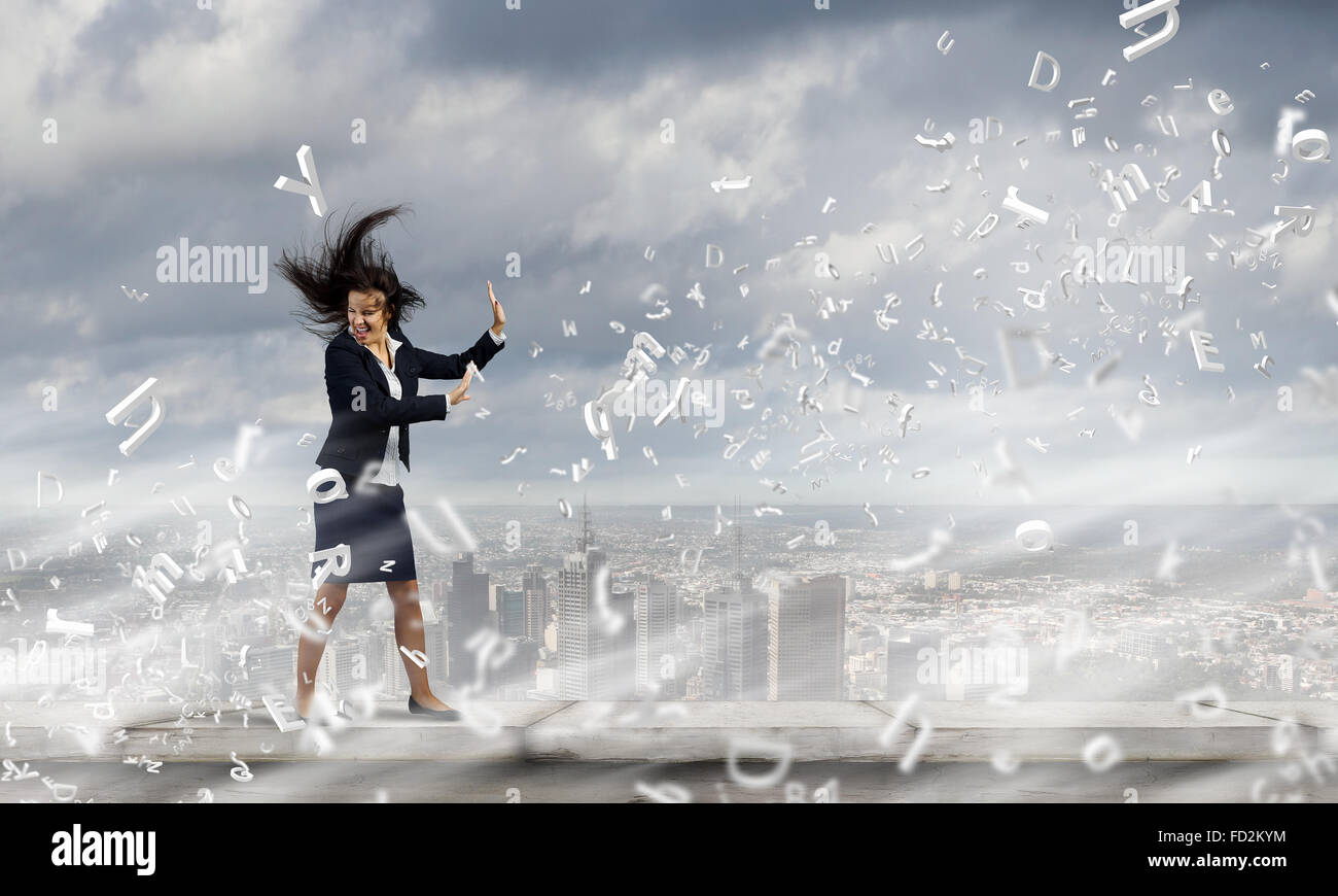 Young determined businesswoman walking against strong wind Stock Photo ...