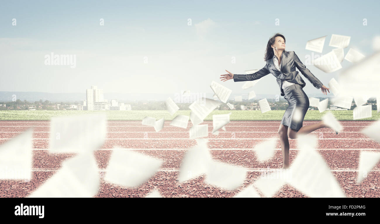 Young businesswoman in suit running on stadium track Stock Photo - Alamy