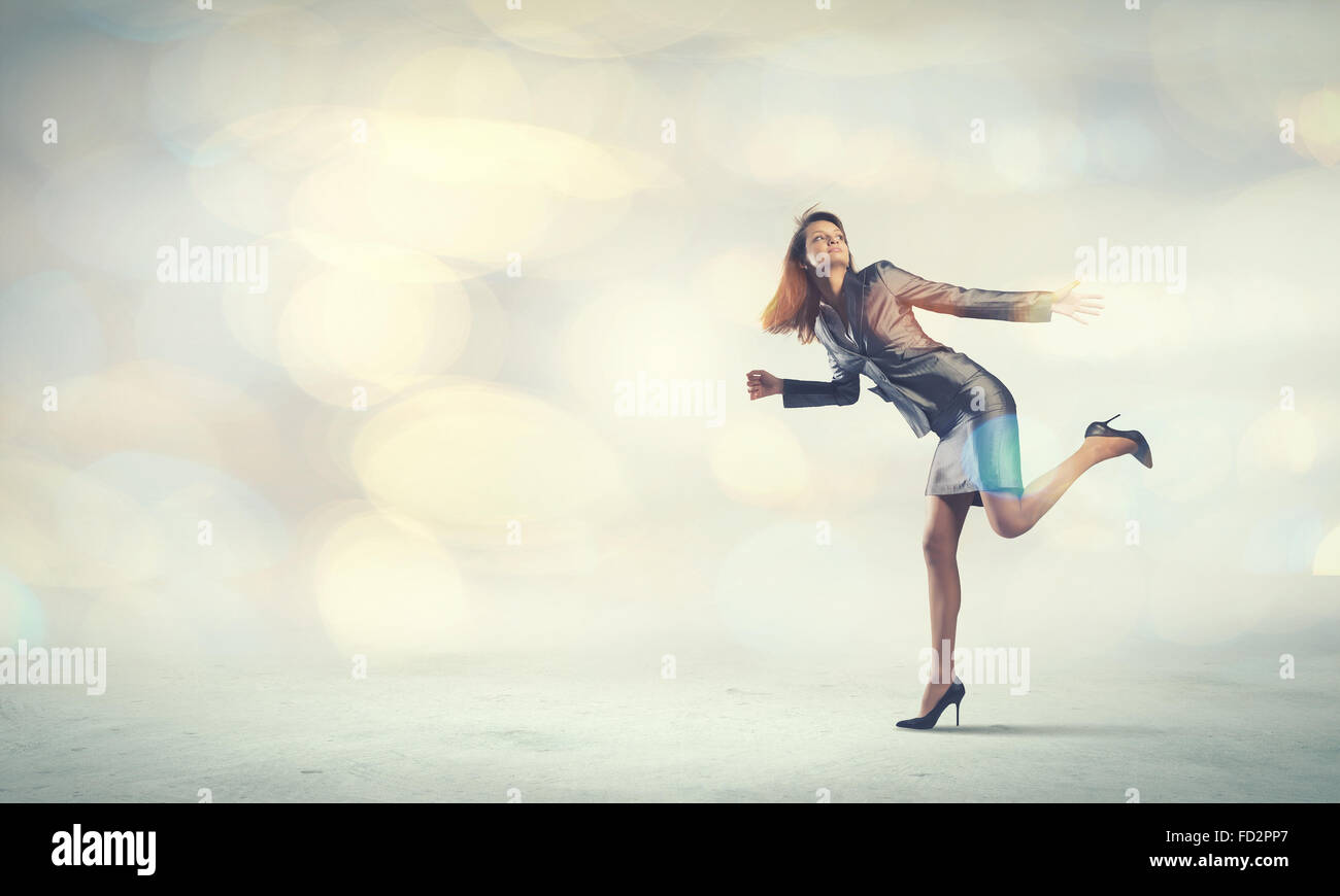 Young businesswoman in suit running against bokeh background Stock ...