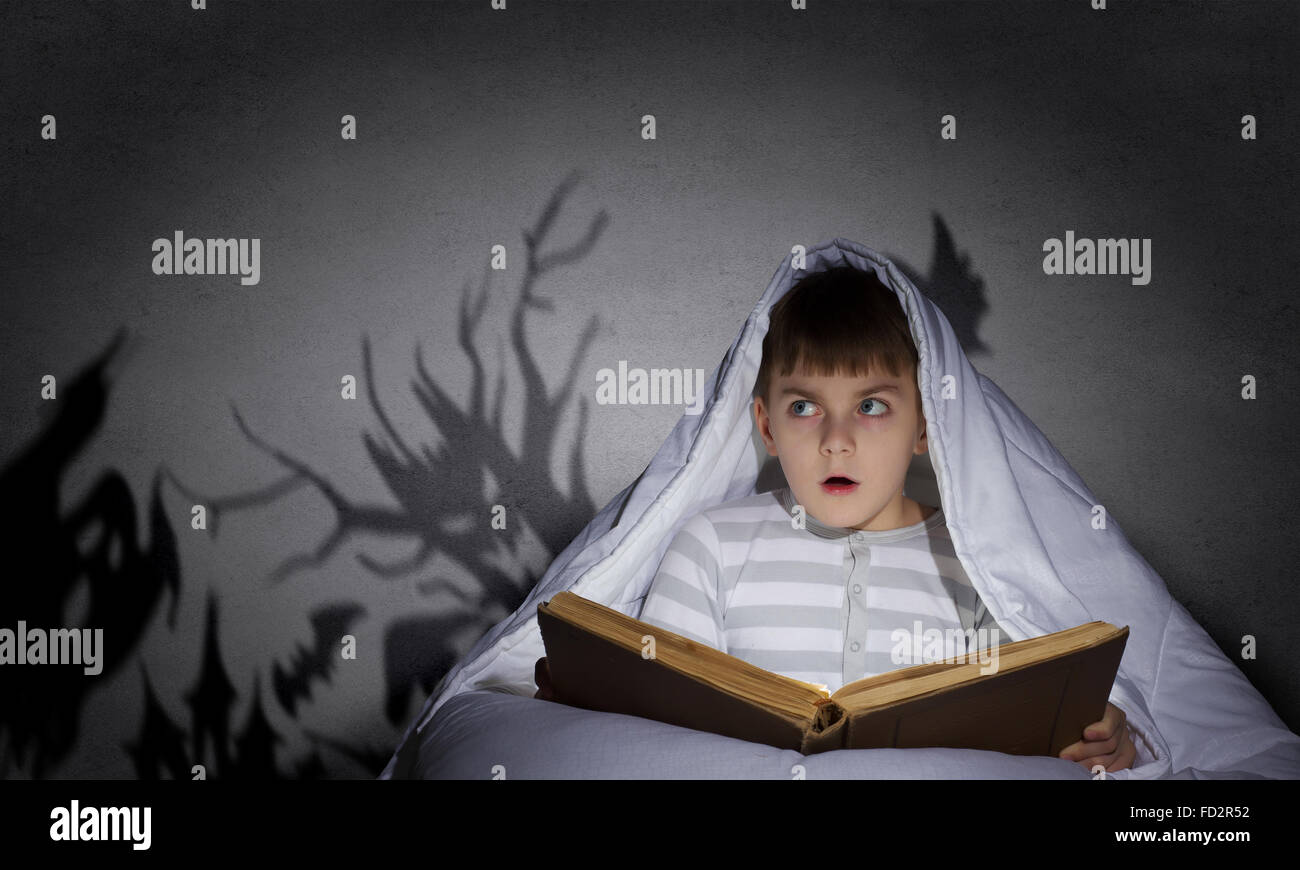 Little scared boy in bed under blanket with flashlight Stock Photo - Alamy