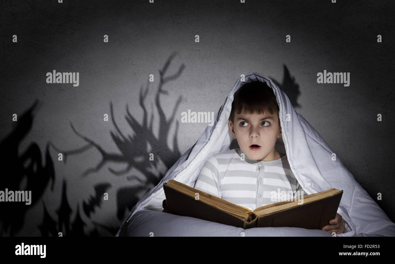 Little scared boy in bed under blanket with flashlight Stock Photo - Alamy