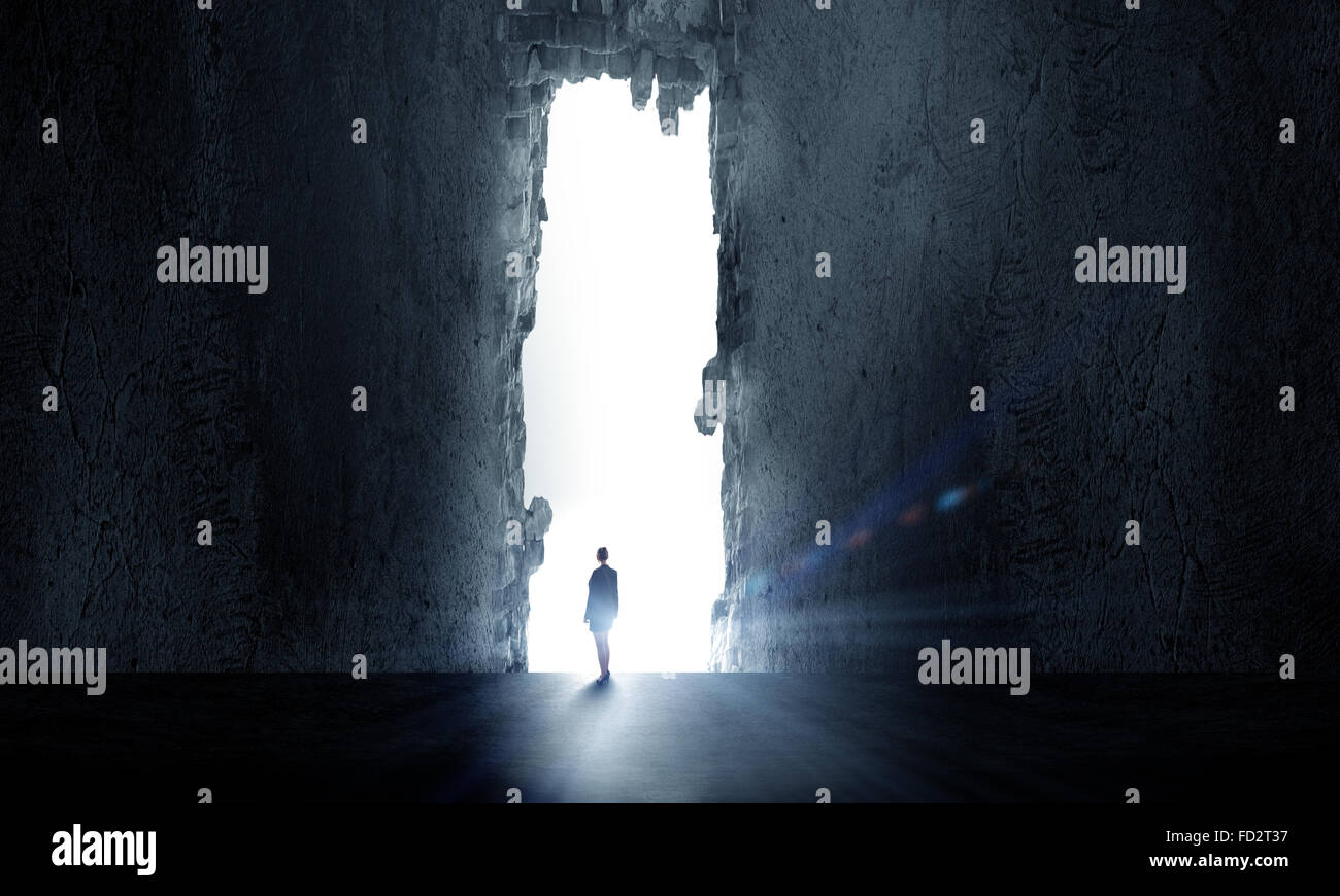 Rear view of businesswoman standing in light of crack in wall Stock ...