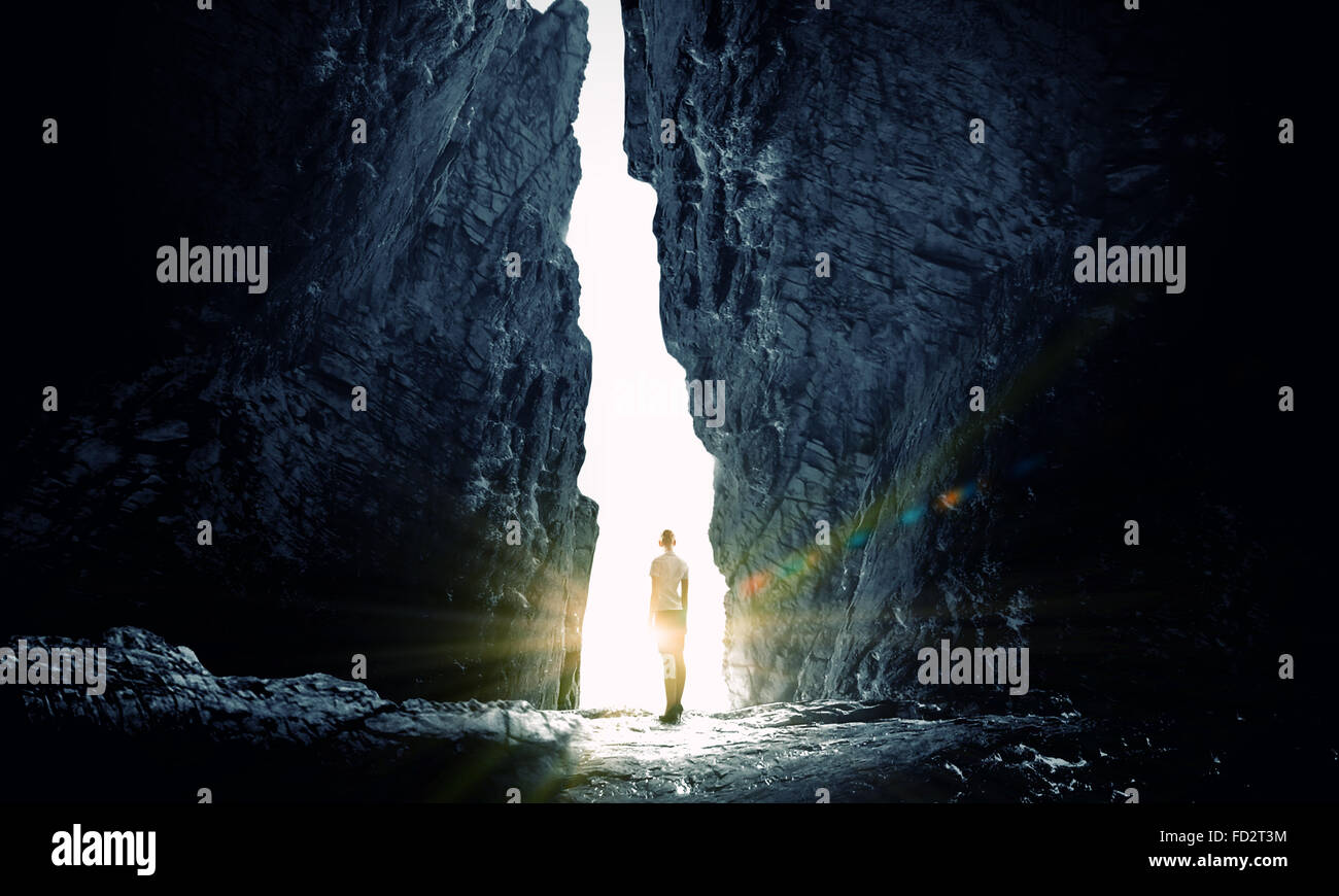 Rear view of businesswoman standing in light of crack in wall Stock ...