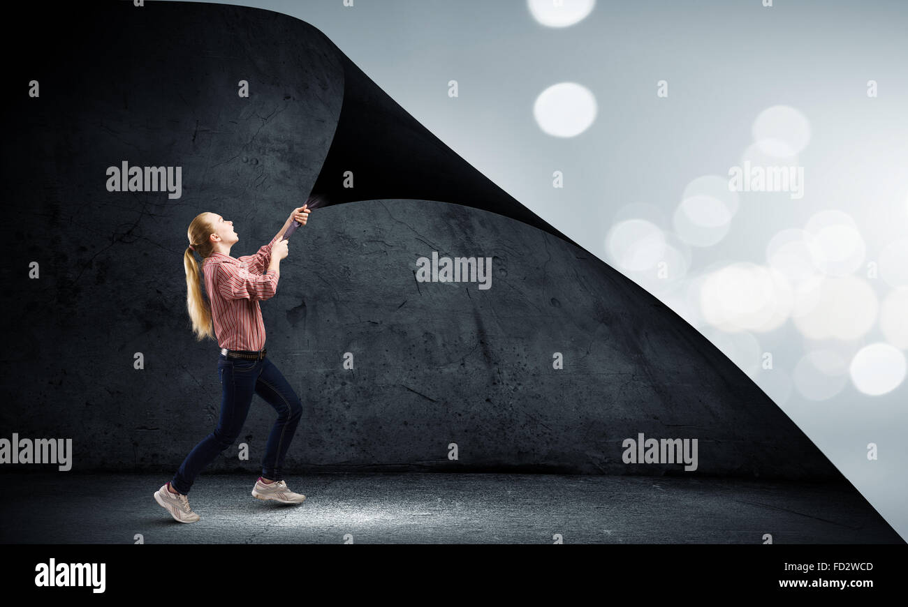 Young woman pulling page to change scene Stock Photo - Alamy
