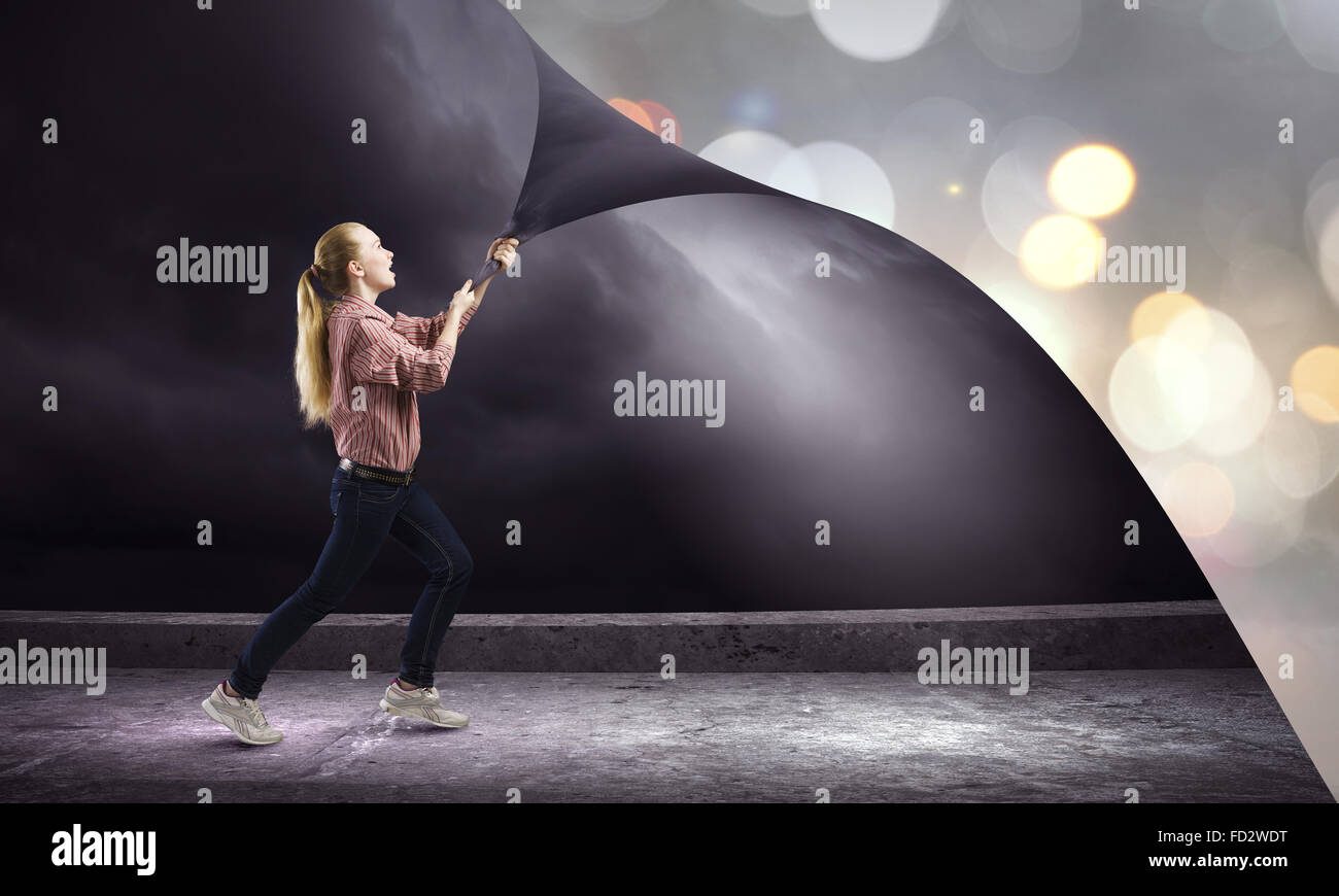 Young woman pulling page to change scene Stock Photo - Alamy